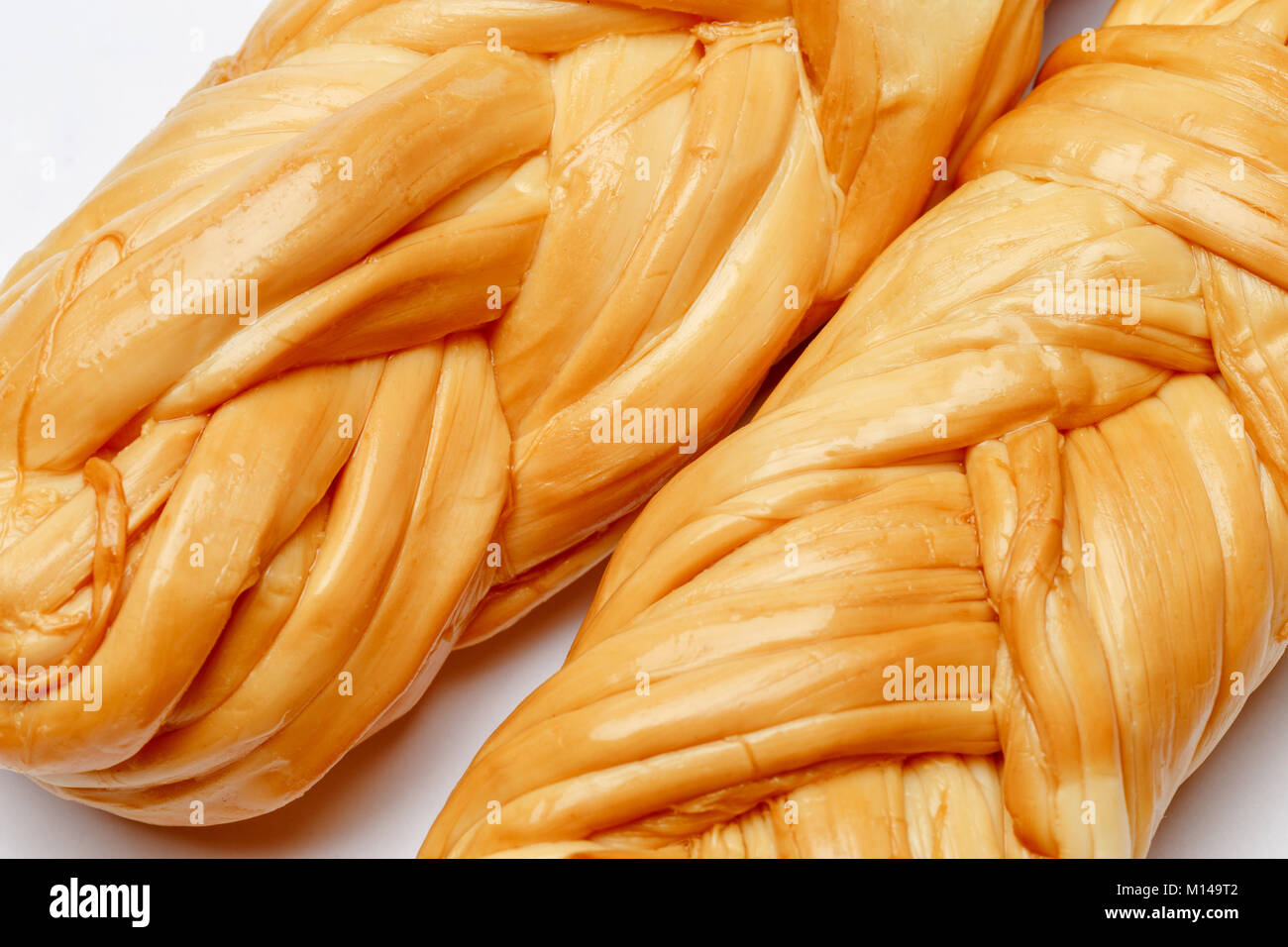 Smoked braided cheese isolated on white background Stock Photo - Alamy