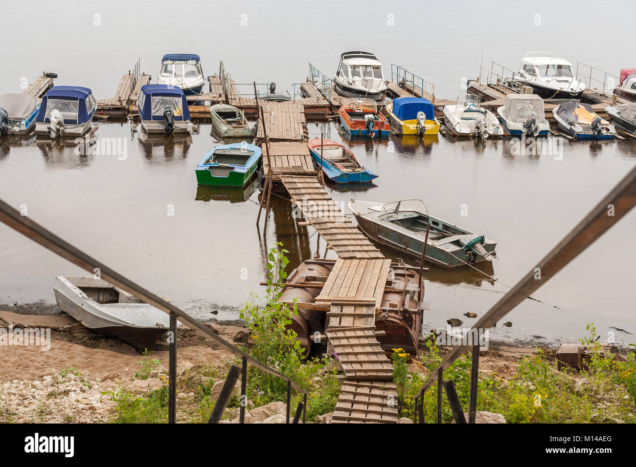 Small wooden bridge and parking lot small boats and motorboats on Volga ...