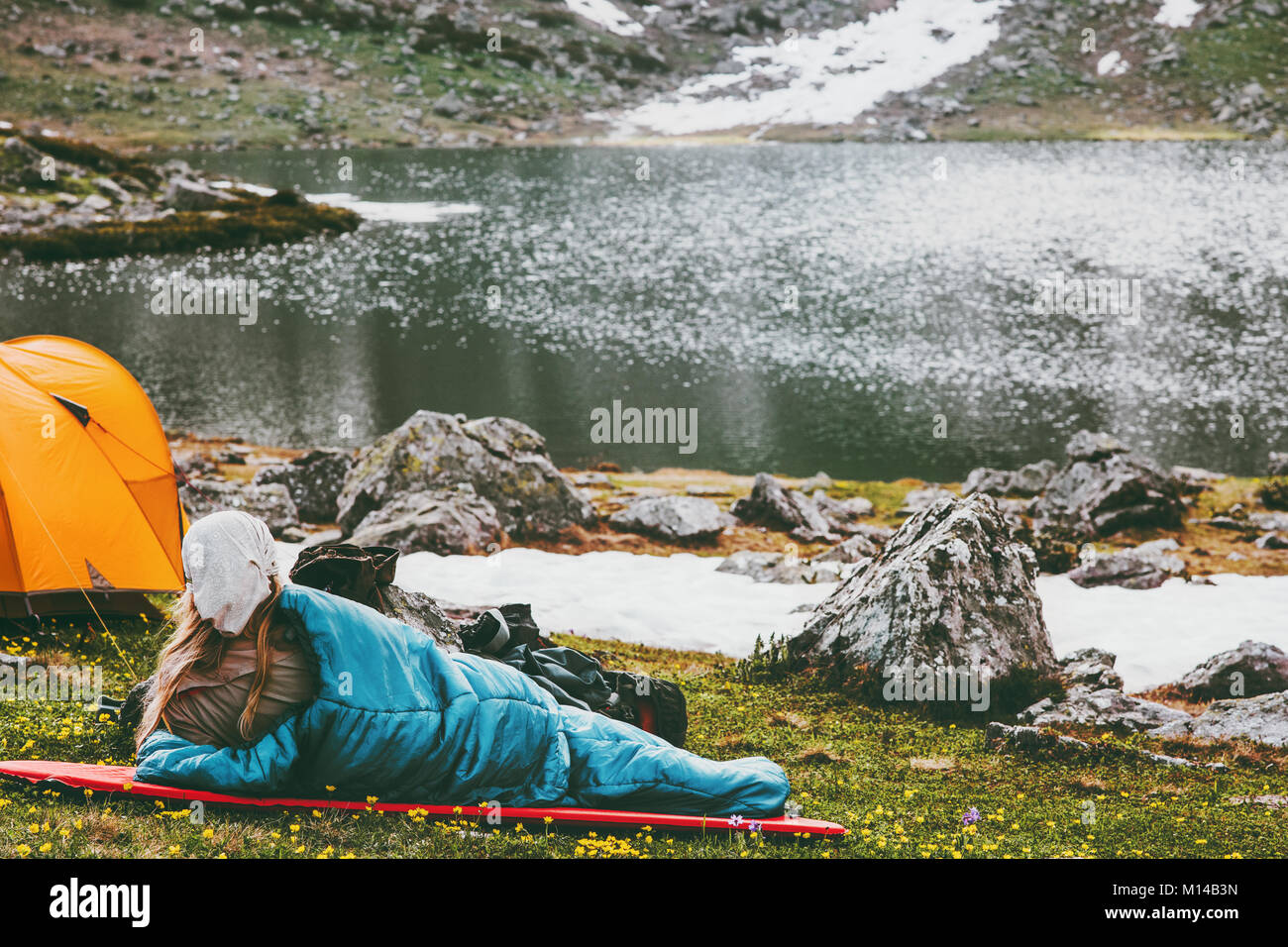 Woman relaxing in sleeping bag on mat enjoying lake landscape Travel ...