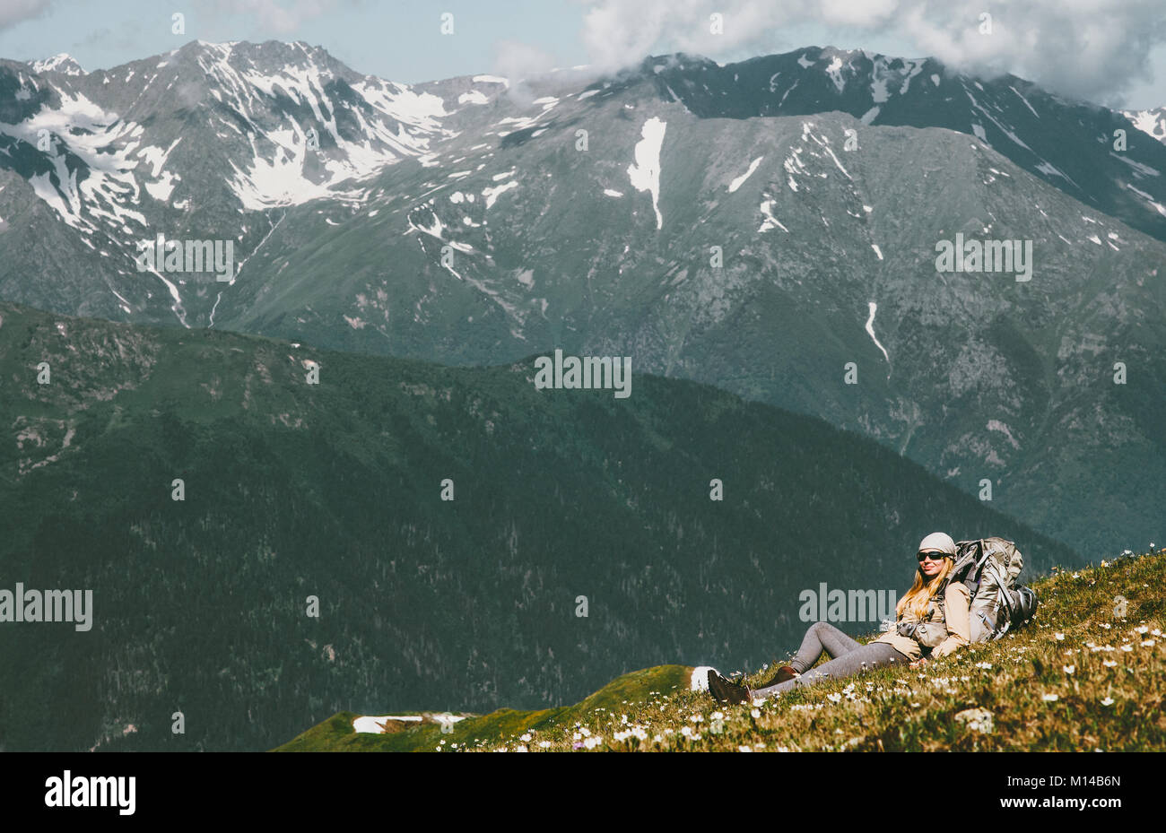 Woman relaxing in mountains laying with backpack wanderlust adventure ...