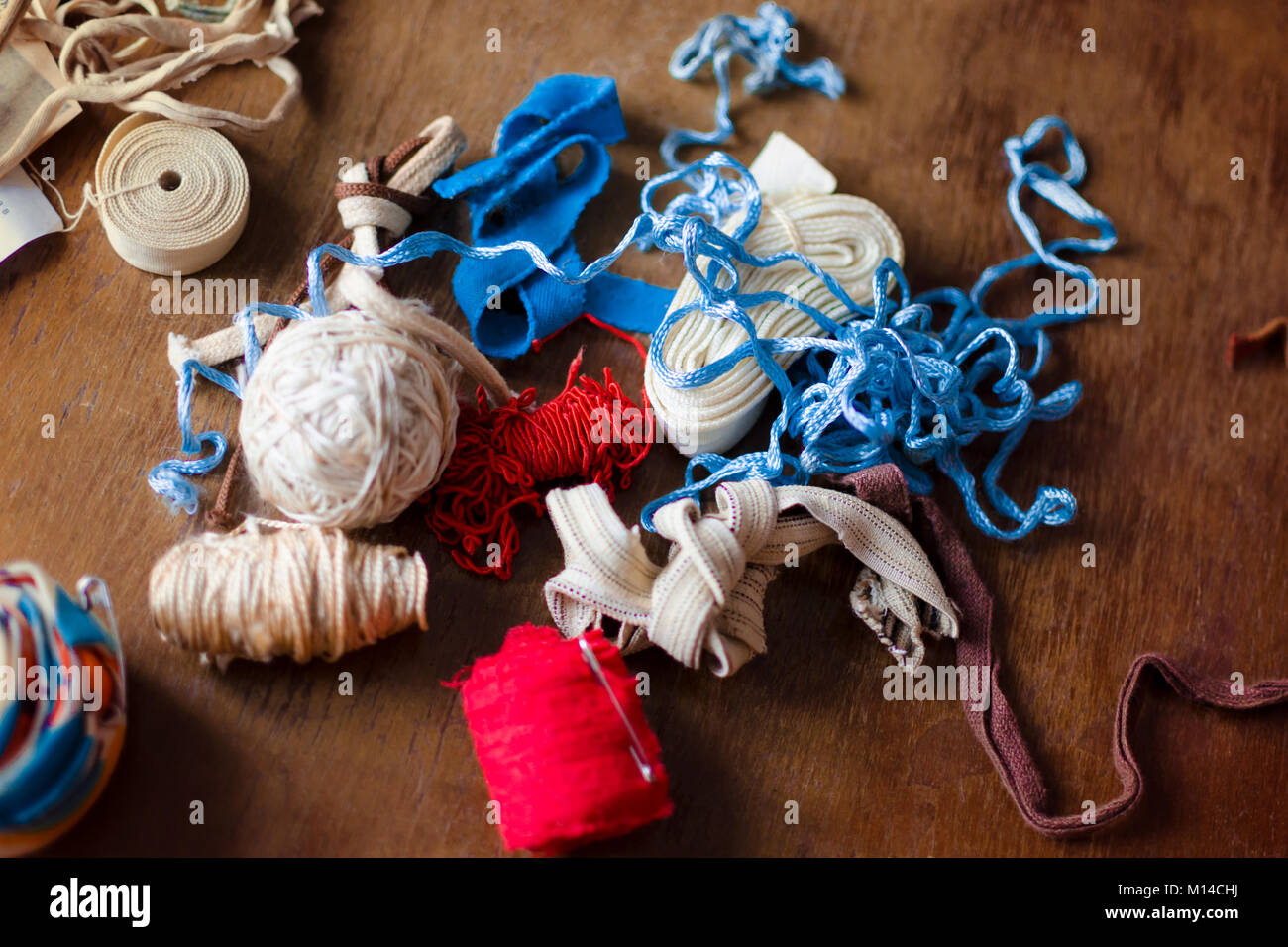 A bunch of colorful red, blue and white old vintage ropes on a brown ...