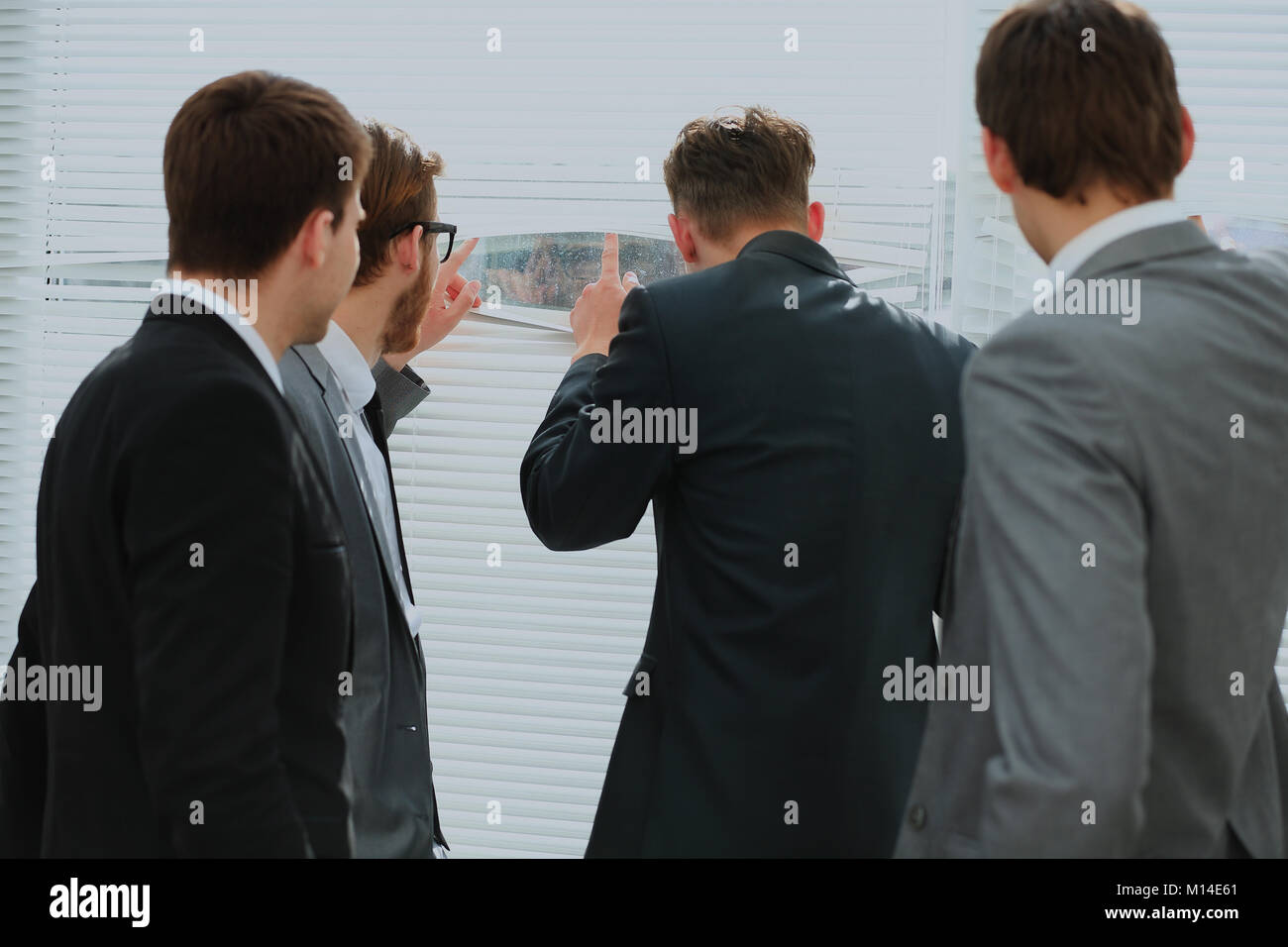 Business team looking through the office window, view from the back ...