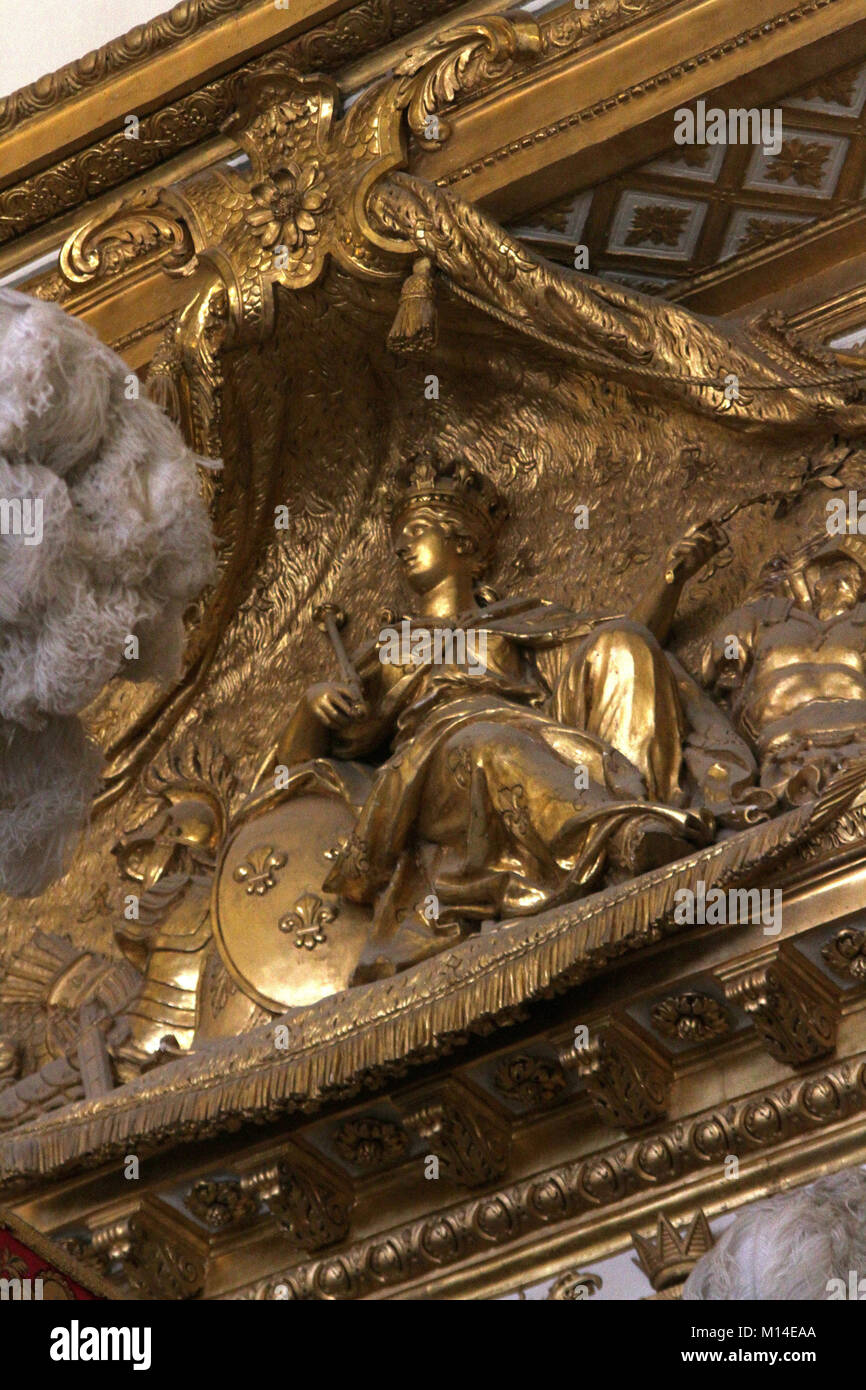 Golden sculpture above the King's bed next to ostrich feathers in the ...