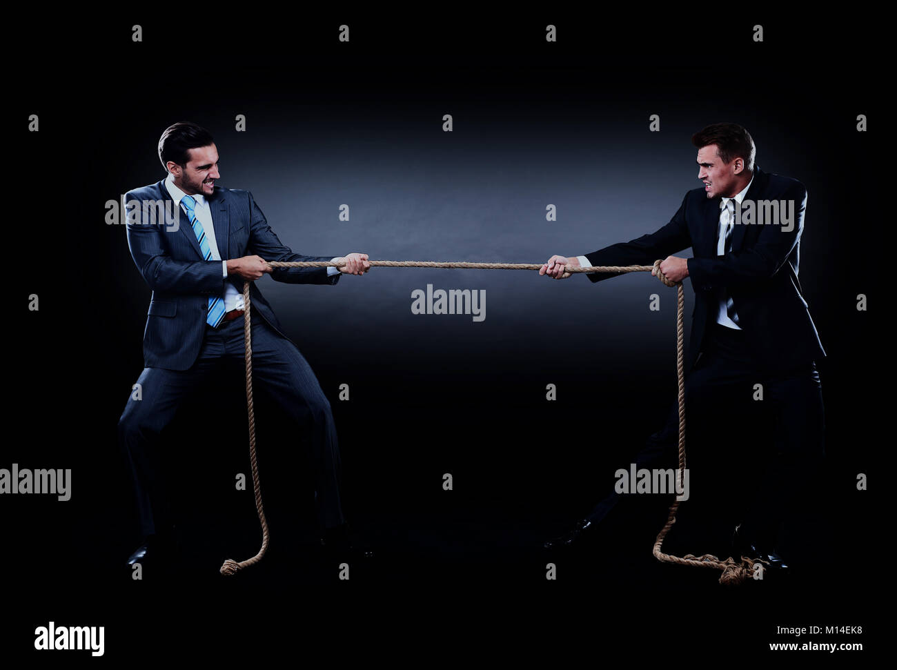 Two business men pulling rope in a competition, isolated on white ...