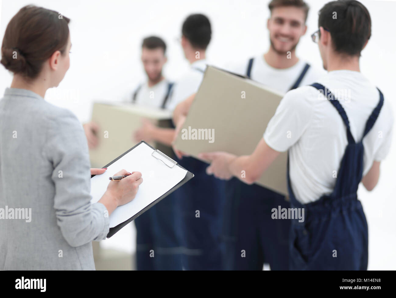 Young female manager and movers isolated on white background Stock ...