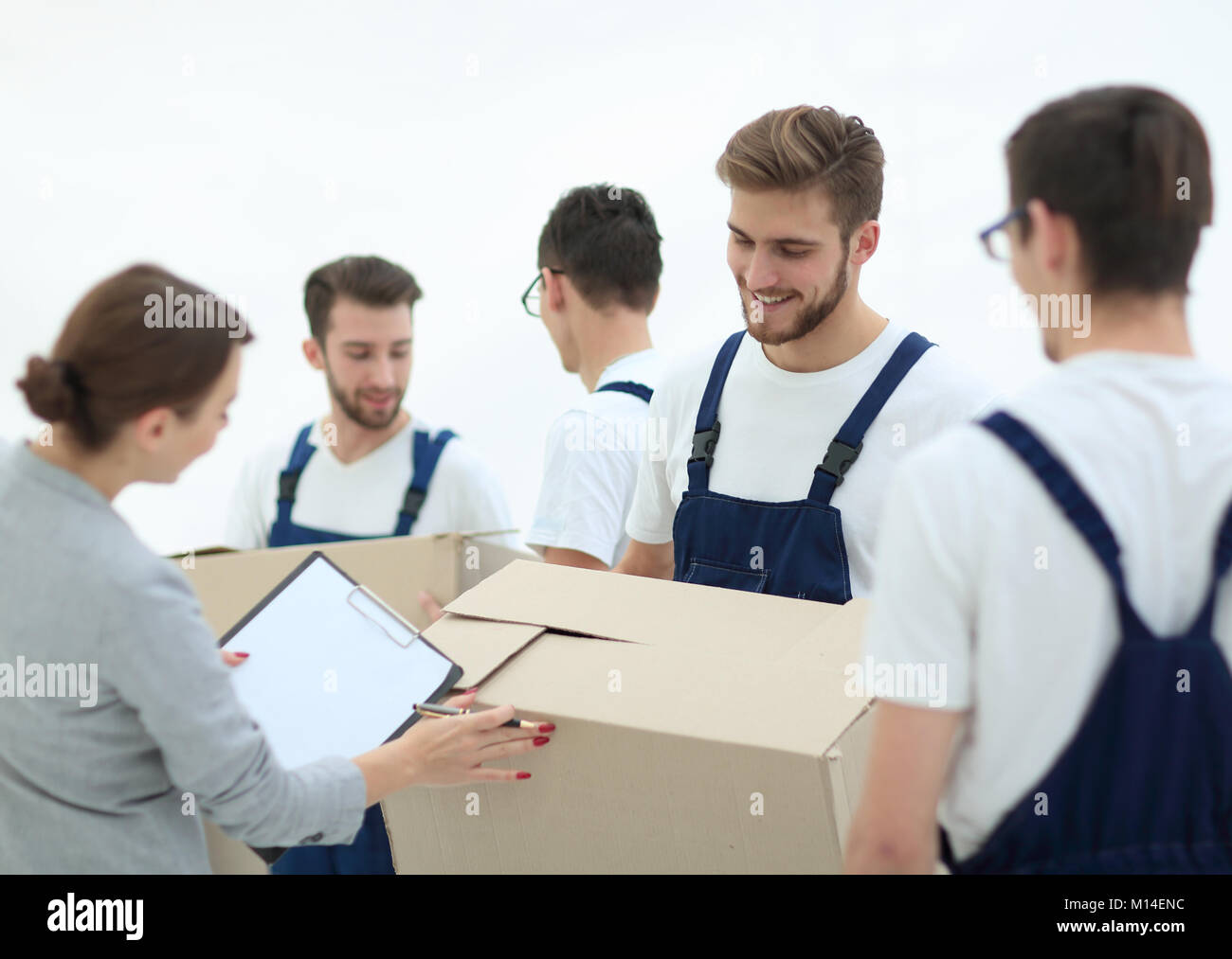 Young female manager and movers isolated on white background Stock ...