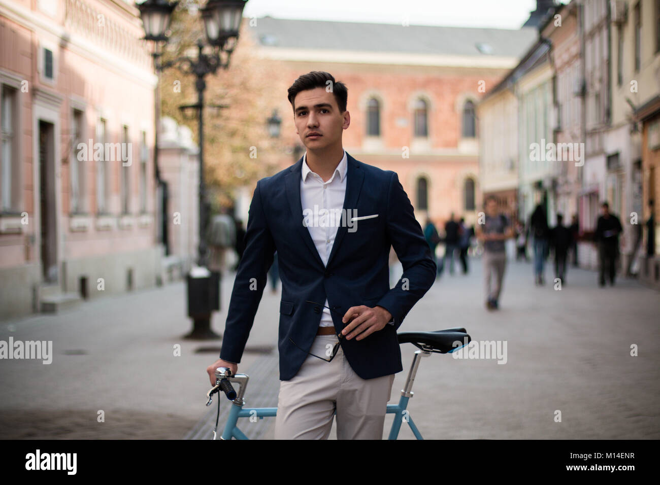Elegant young man with blue bicycle outdoors on the street Stock Photo ...