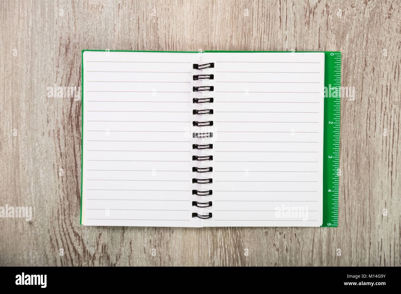 Open notebook with pages in line on table Stock Photo - Alamy