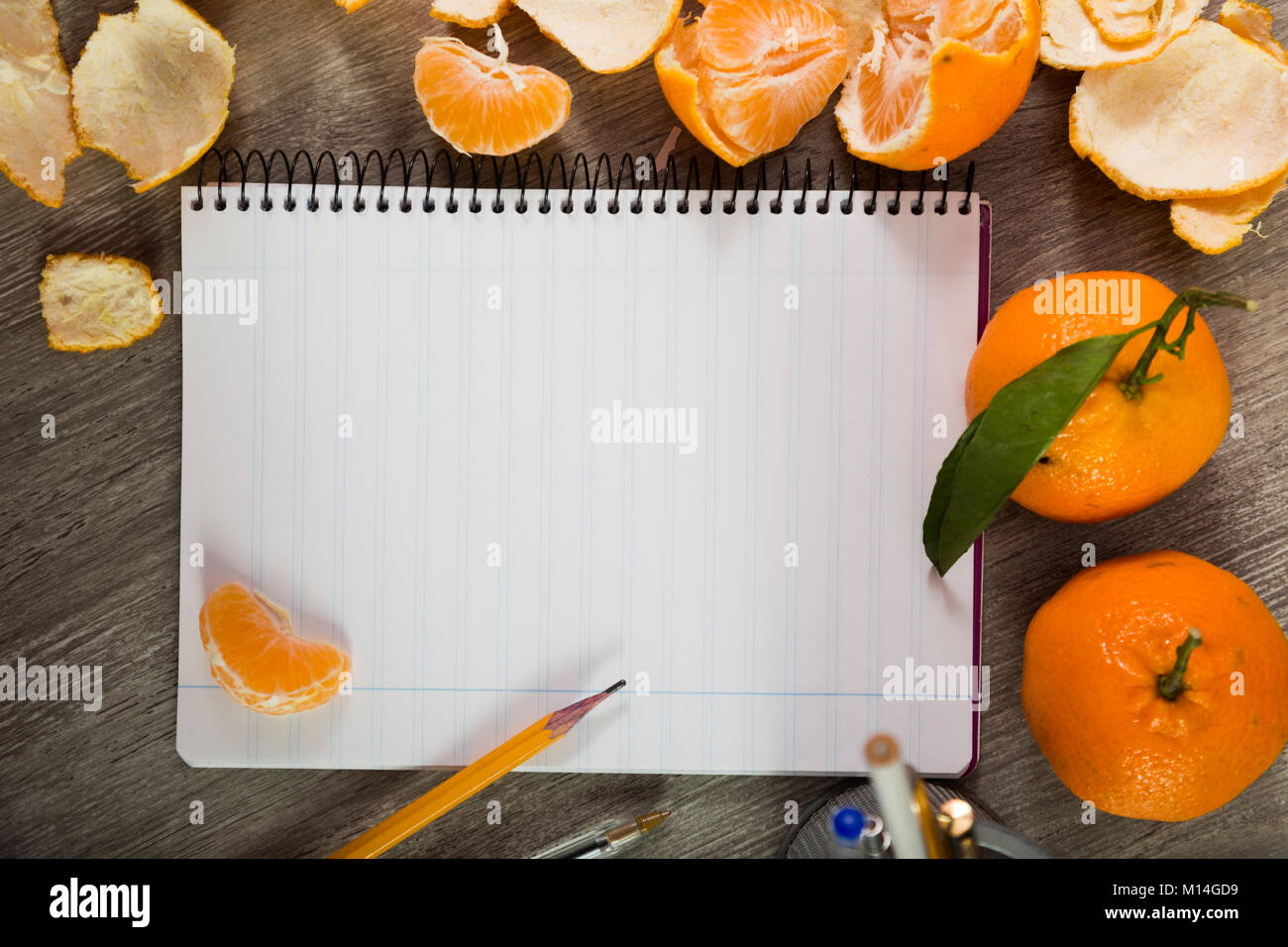 Notebook in range with writing utensils surrounded by fruit Stock Photo ...