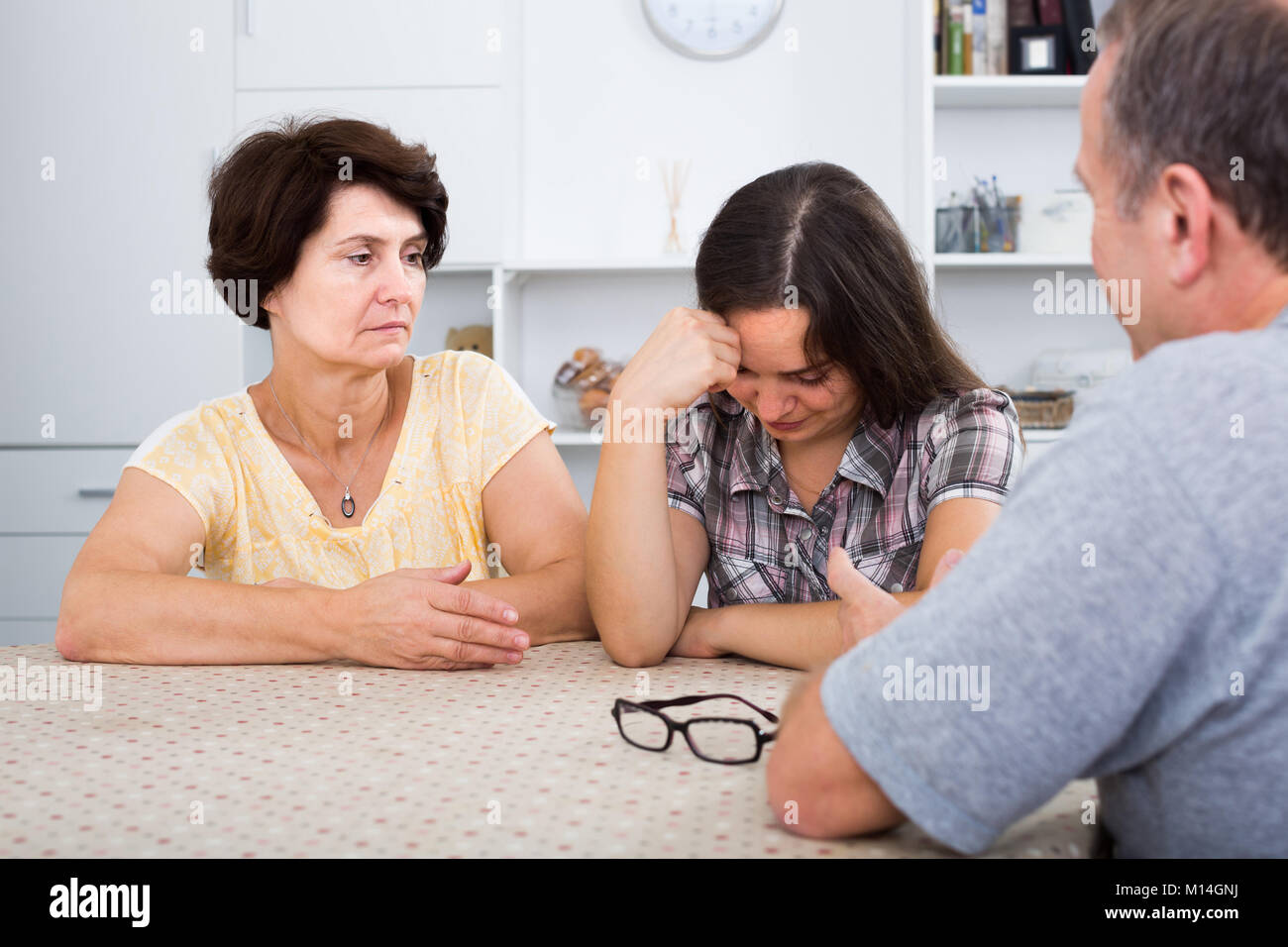 Sad daughter is annoyed by her retiree parents indoors Stock Photo - Alamy