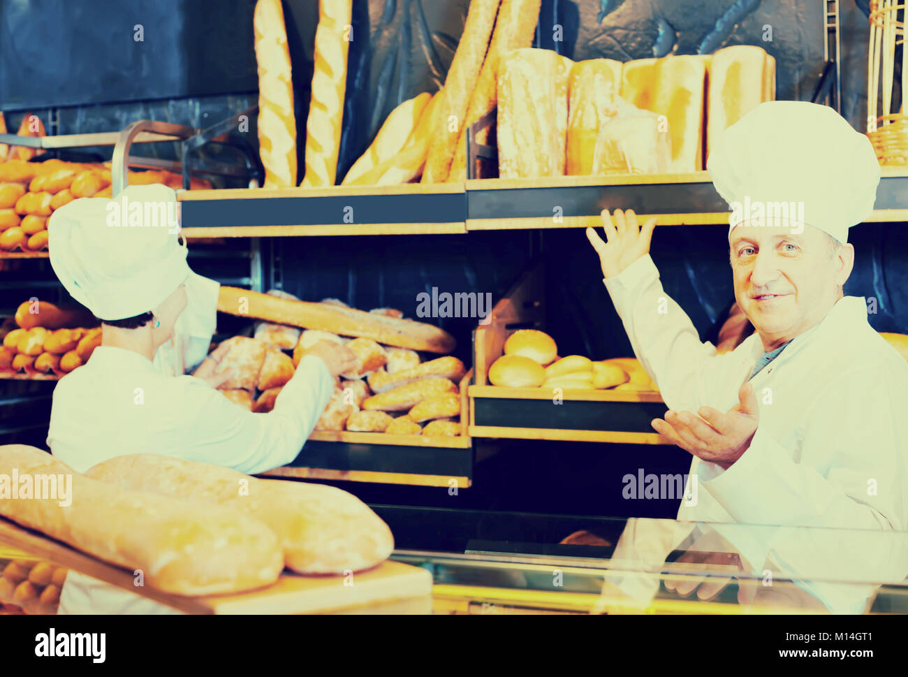 Portrait of friendly bakers with fresh bread smiling in bakery Stock ...