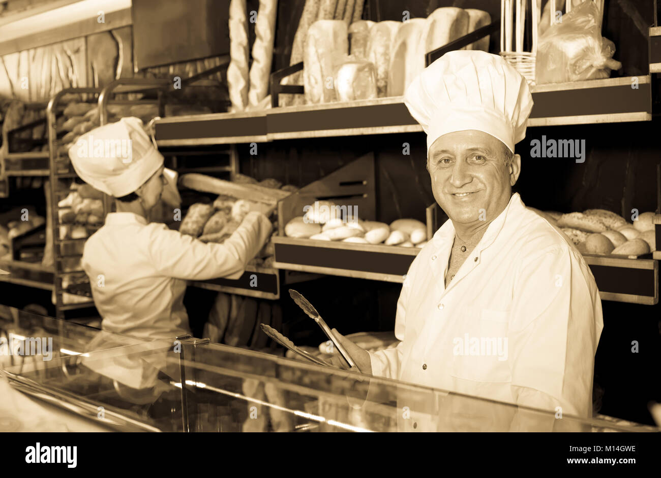 Portrait of satisfied bakers with fresh bread smiling in bakery Stock ...