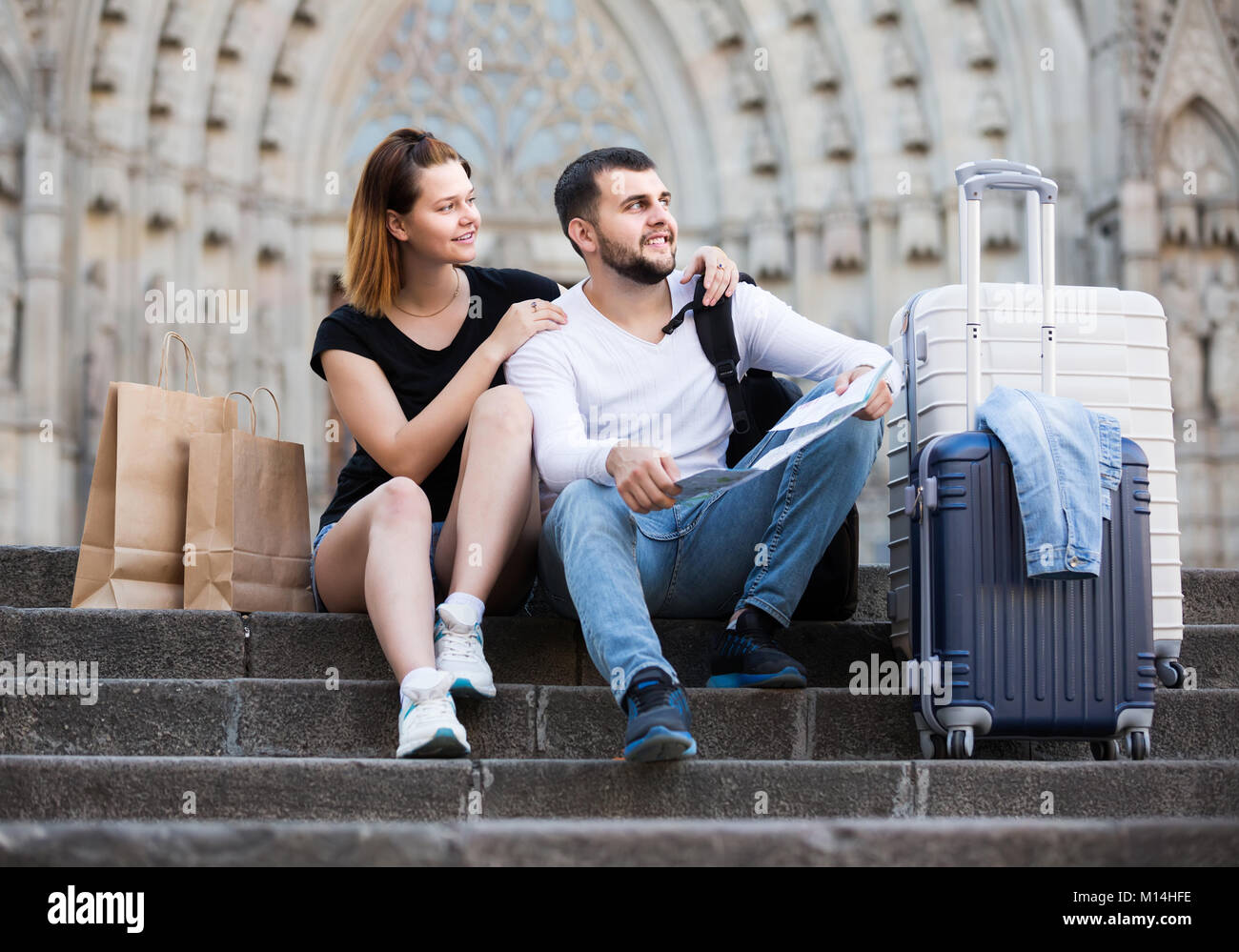 Cheerful spanish man and woman sitting the historic center with map and ...