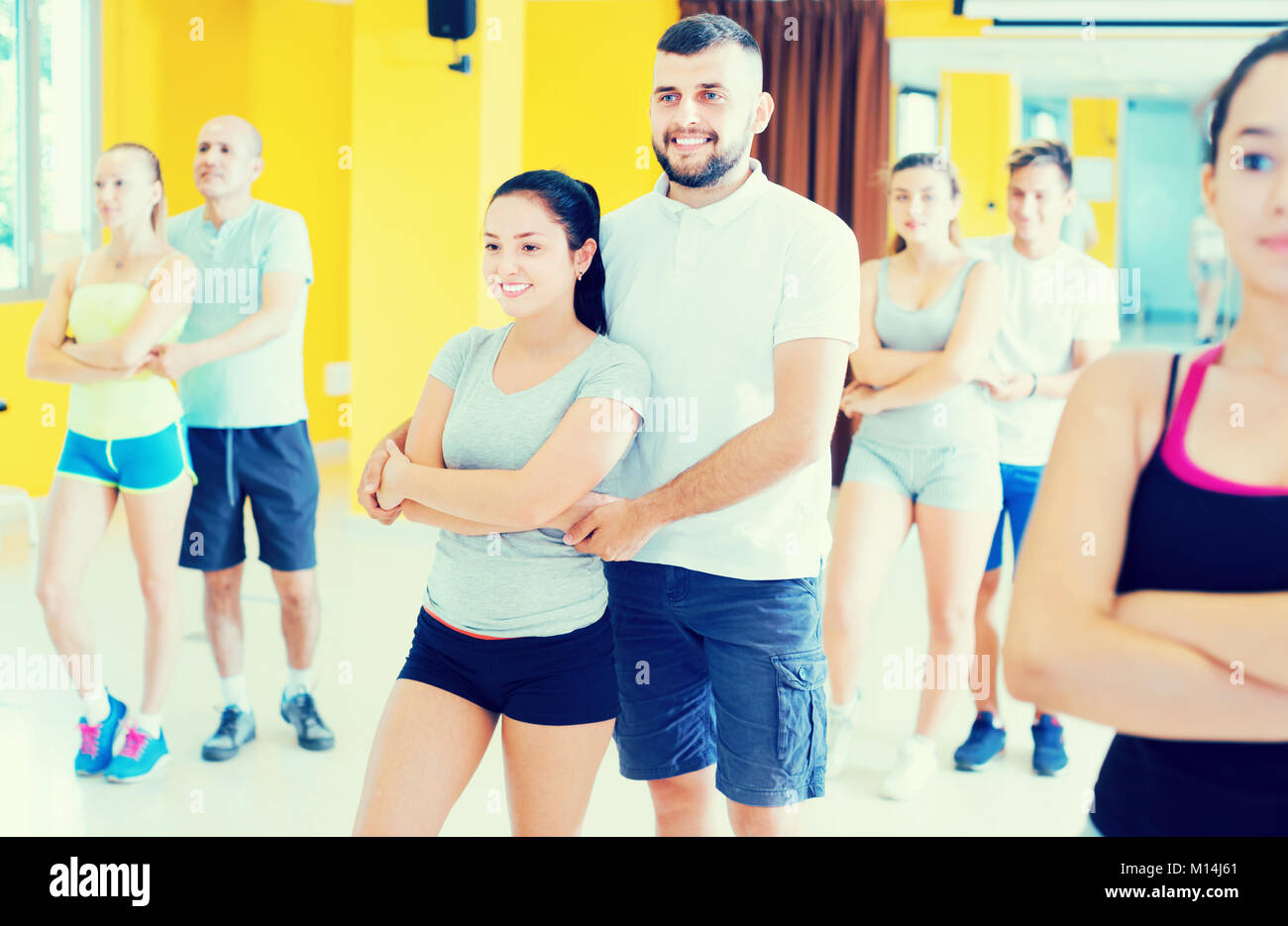 Positive people dancing bachata together in modern dance studio Stock ...