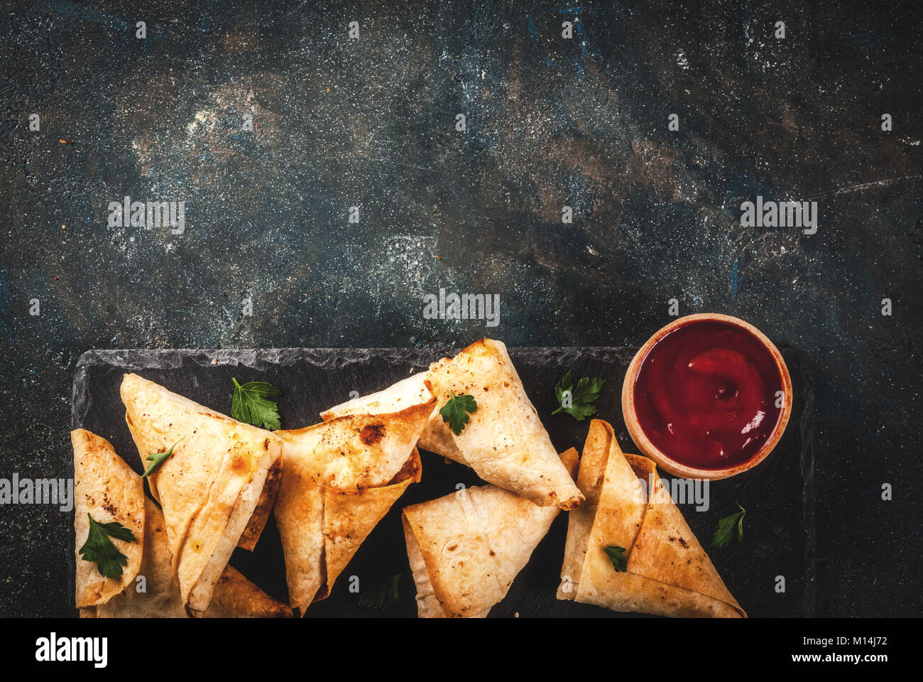 Asian food. Vegetarian samsa (samosas) with tomato sauce. Dark blue background copy space top ...