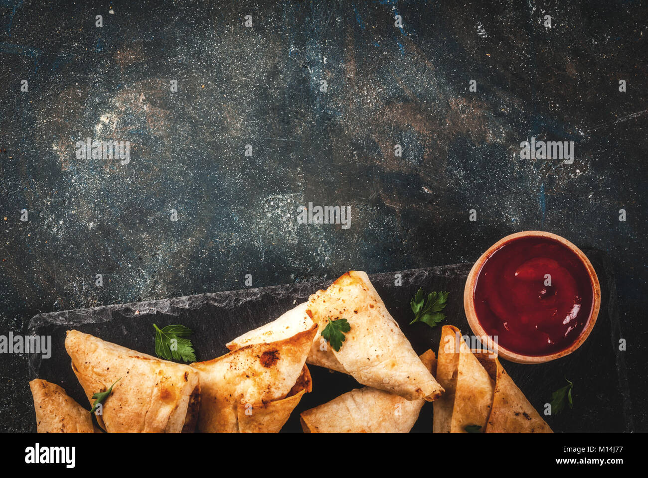 Asian food. Vegetarian samsa (samosas) with tomato sauce. Dark blue background copy space top ...