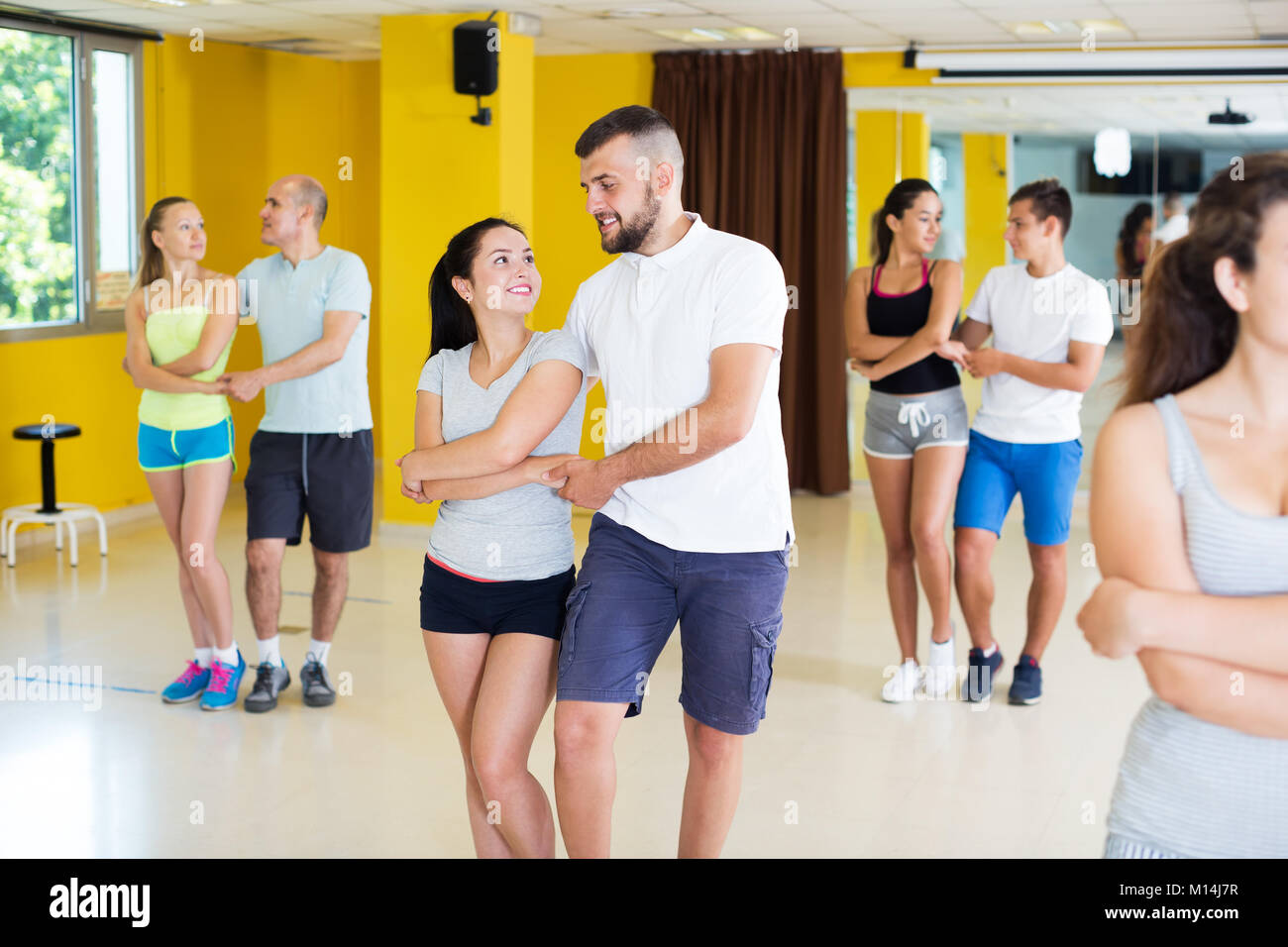 Smiling adults dancing salsa together in dance hall Stock Photo - Alamy