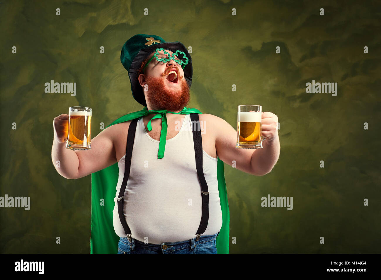 A fat man with a beard in St. Patrick's suit is smiling with a m Stock ...