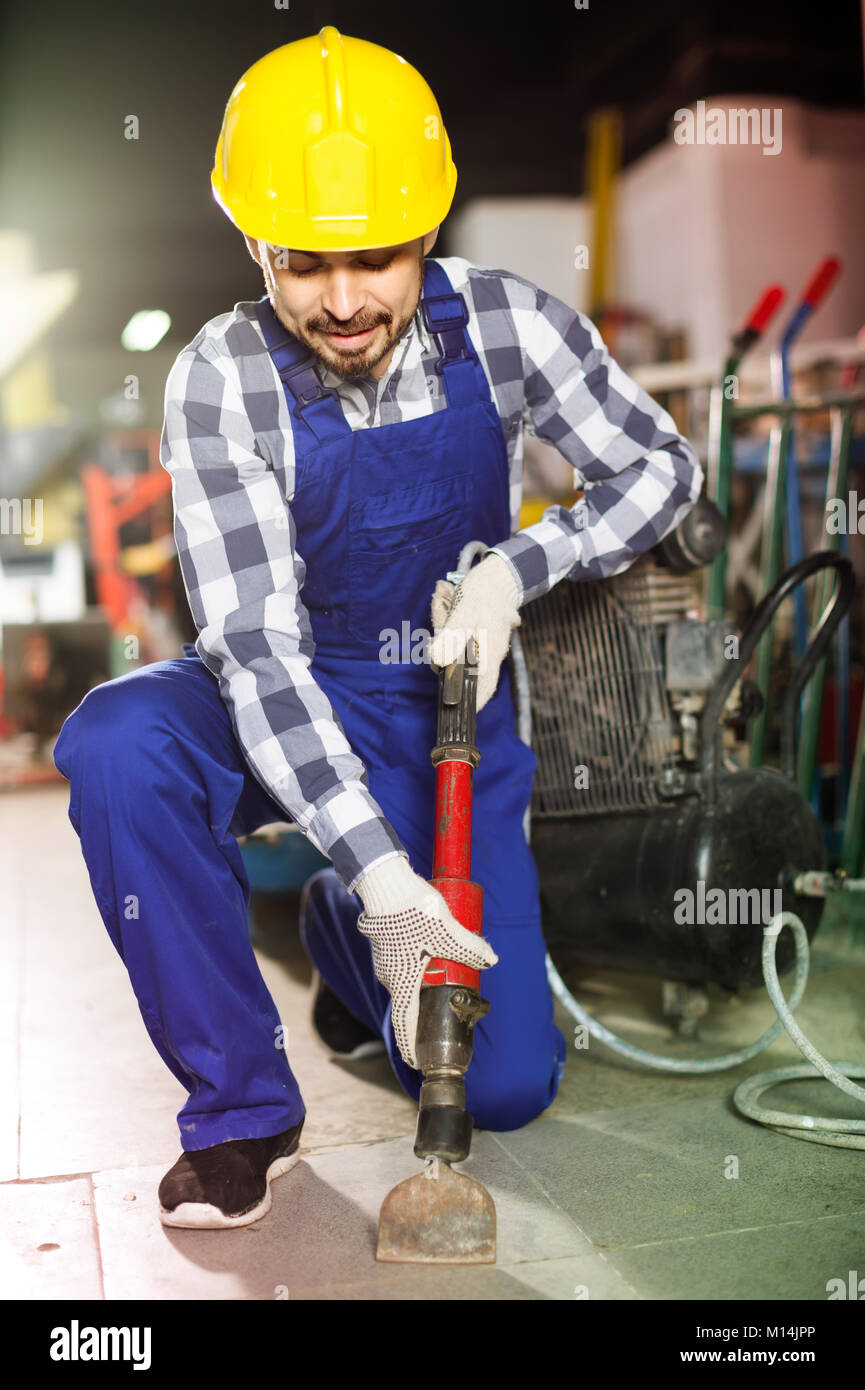 positive germany working man practicing his skills with pneumatic drill ...