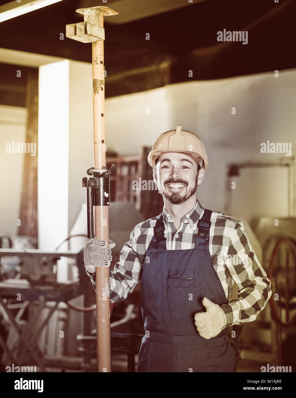 Smiling european working man practicing his skills erect trestle at ...
