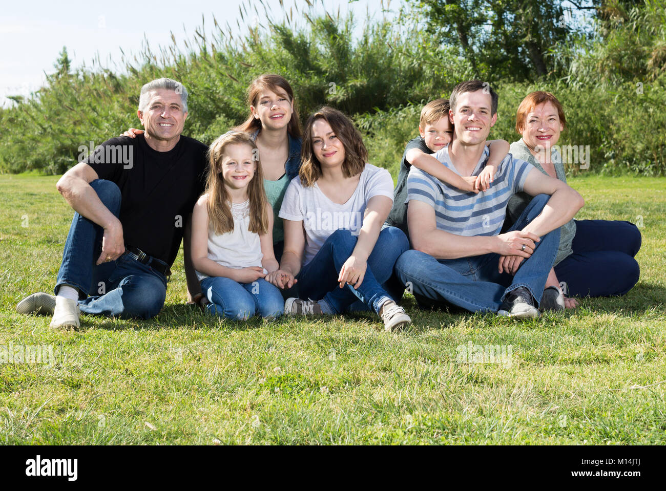Cheerful people of different ages taking photos on the lawn Stock Photo ...