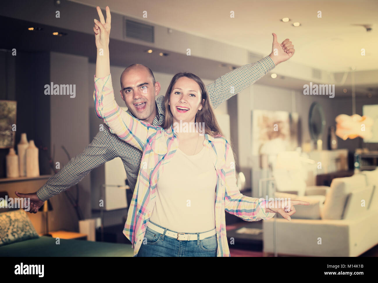Happy married couple posing together in modern home furnishings store ...