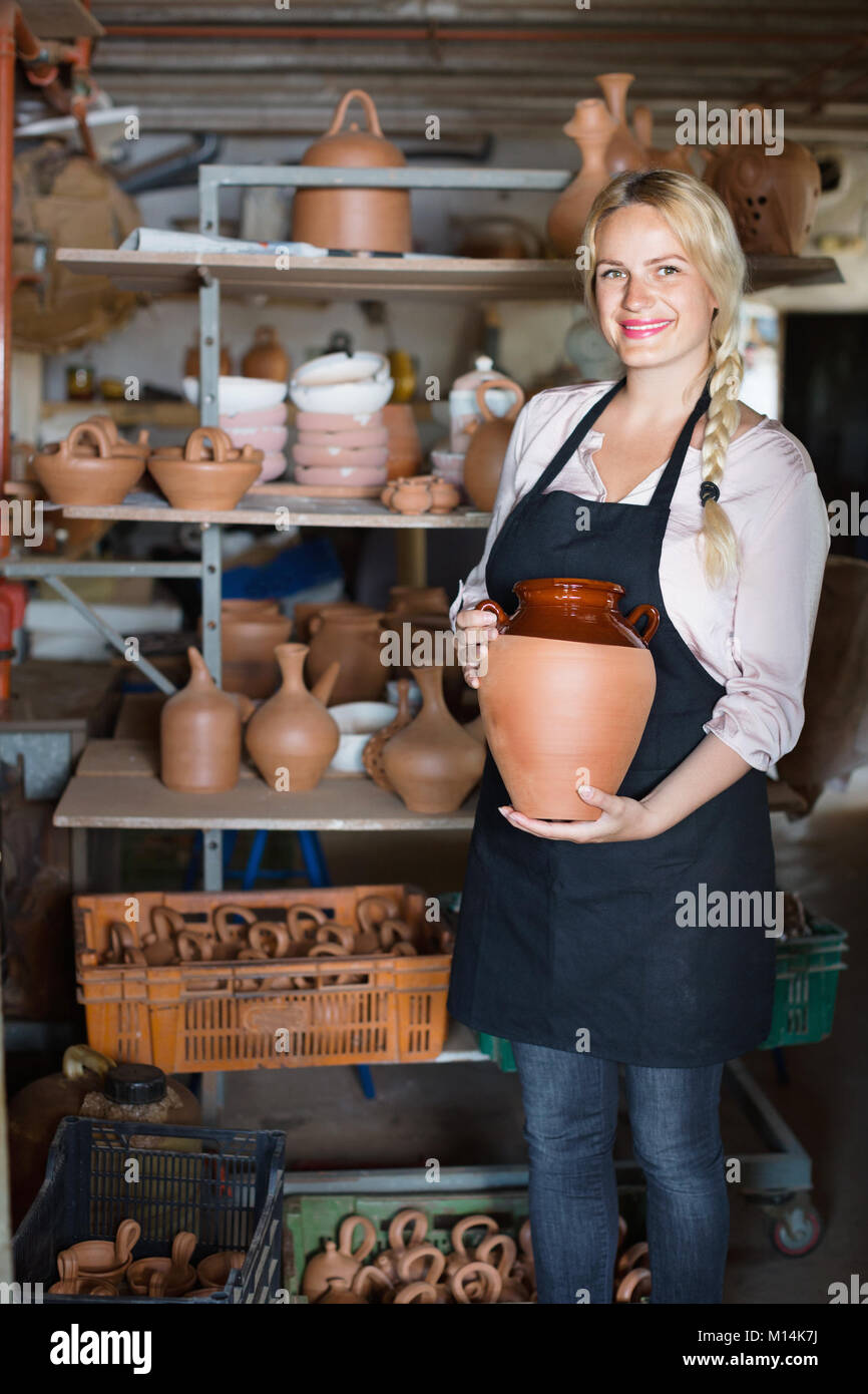 Portrait of positive smiling efficient woman pottery worker with ...