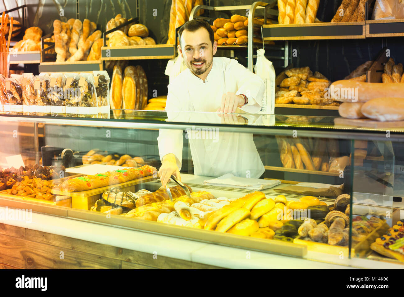 Positive Russian Male Shop Assistant Demonstrating Fresh Delicious