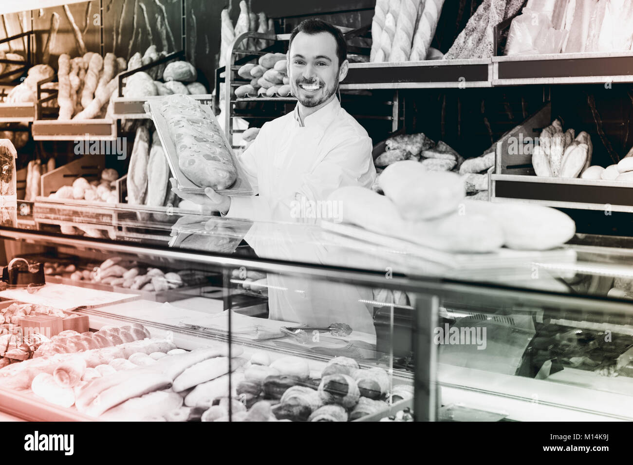 Male seller is offering fresh festive cake in bakery Stock Photo - Alamy