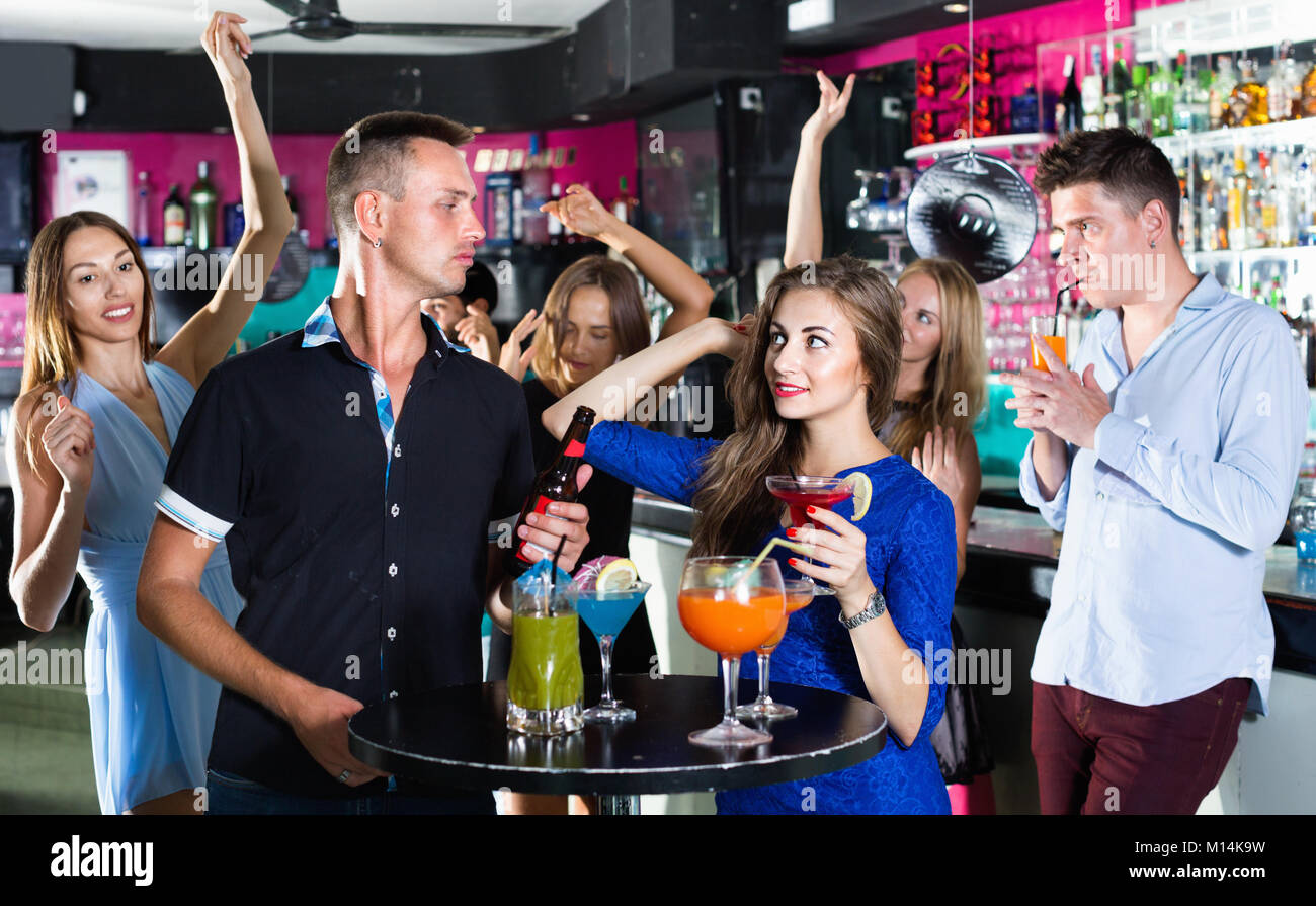 Happy cheerful man with woman are drinking cocktails on corporate party ...