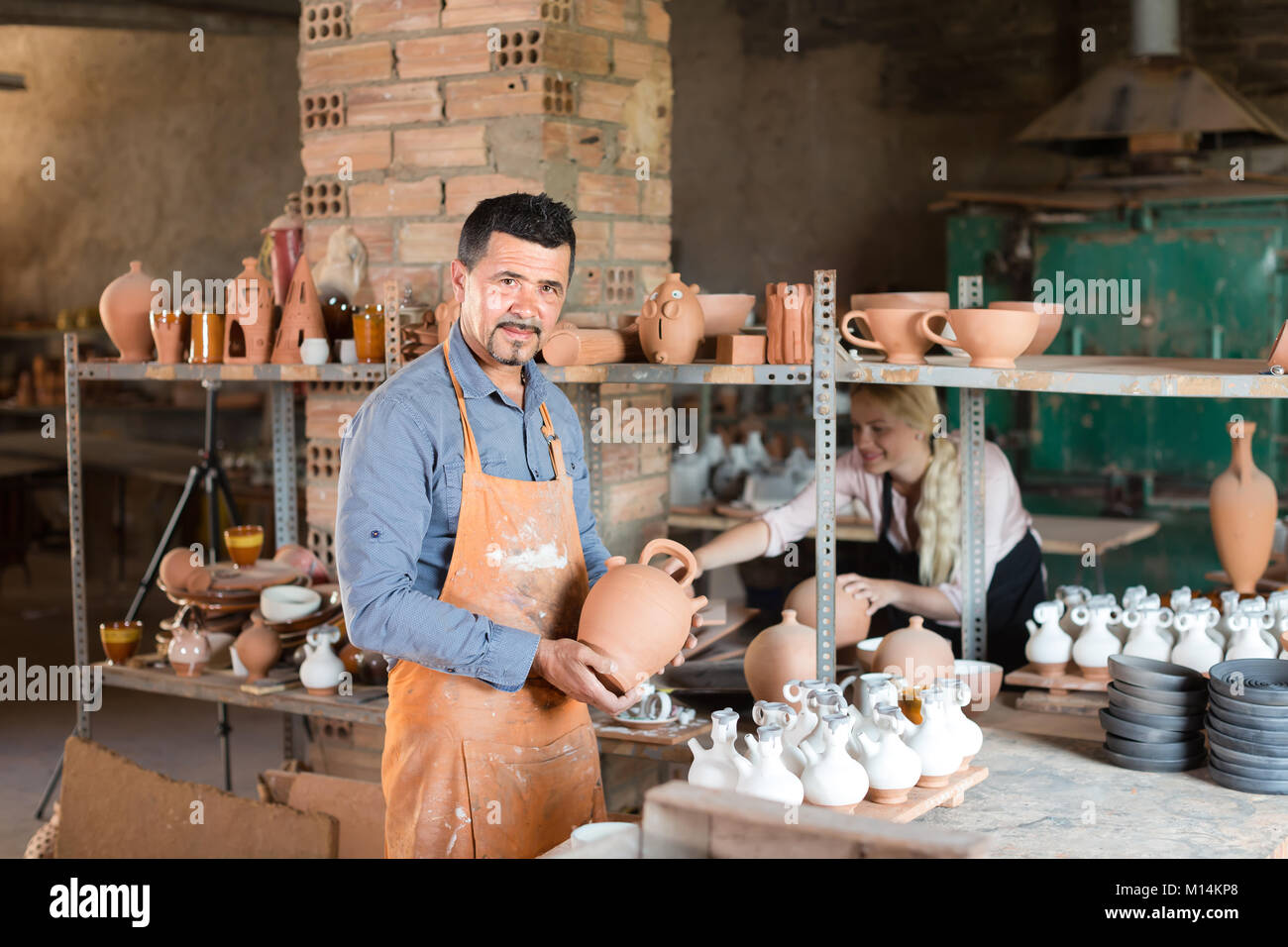 Professional man and woman potters working in pottery workshop Stock ...
