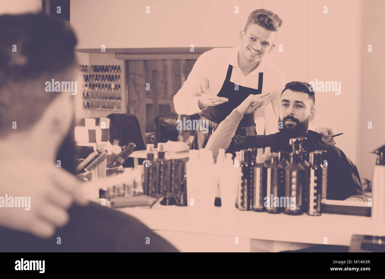 Positive client making specifications about haircut with hairdresser at ...