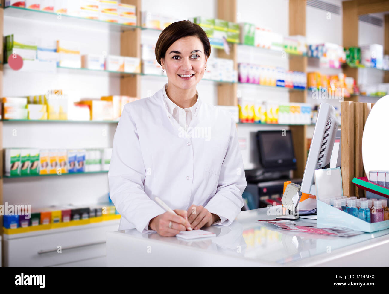 Smiling italian female pharmacist checking assortment of drugs in ...