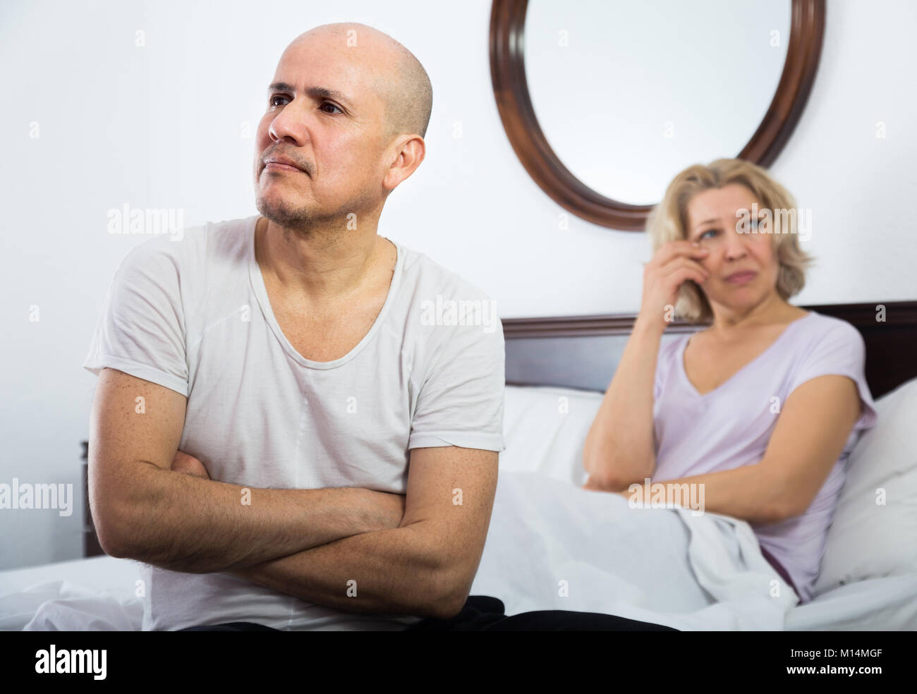 Frustrated aged man and his wife sorting out relationships in bed Stock ...