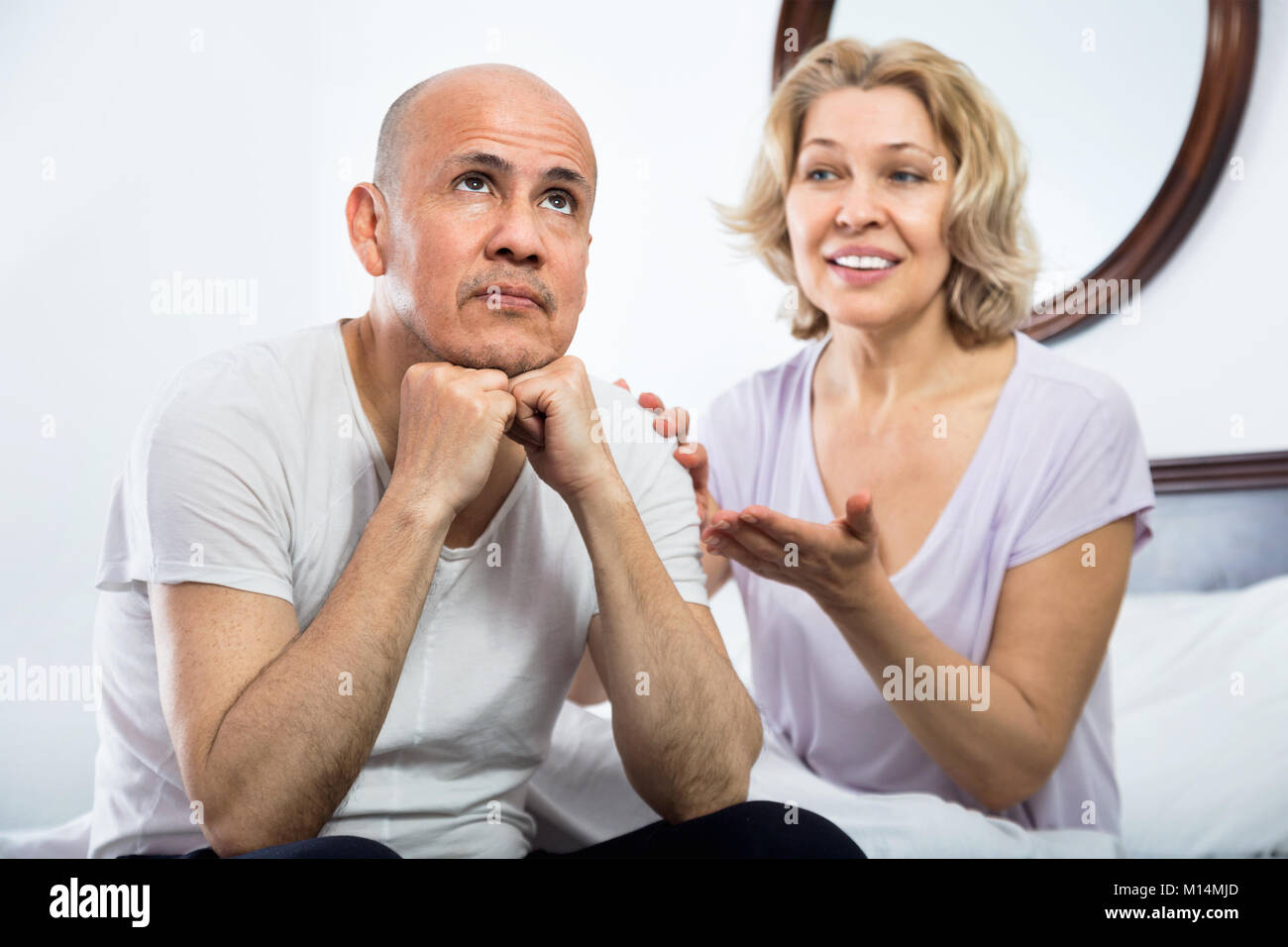 Calm tranquil mature girlfriend consoling grieving man sitting apart ...