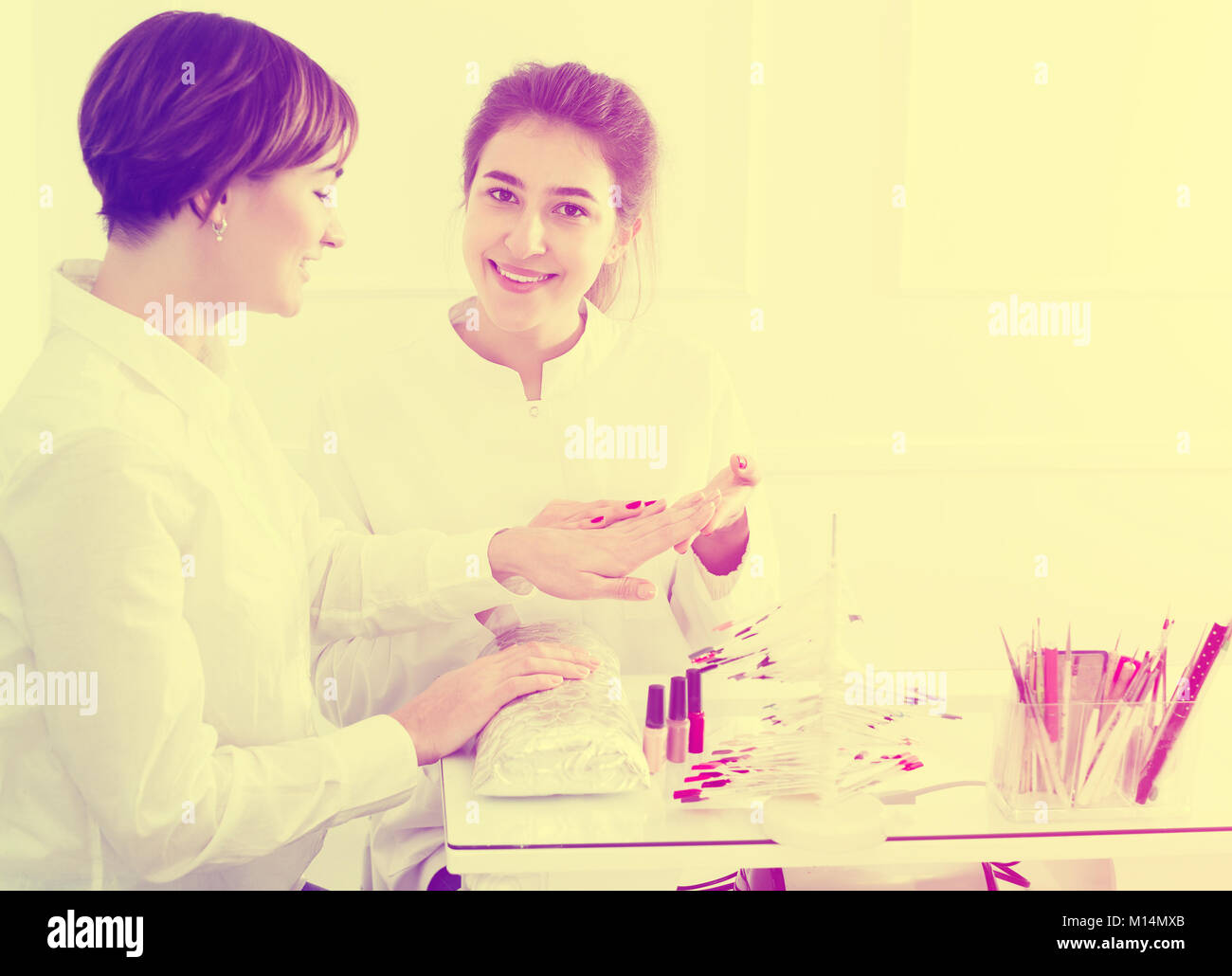 Happy young woman client having manicure done in nail salon Stock Photo ...