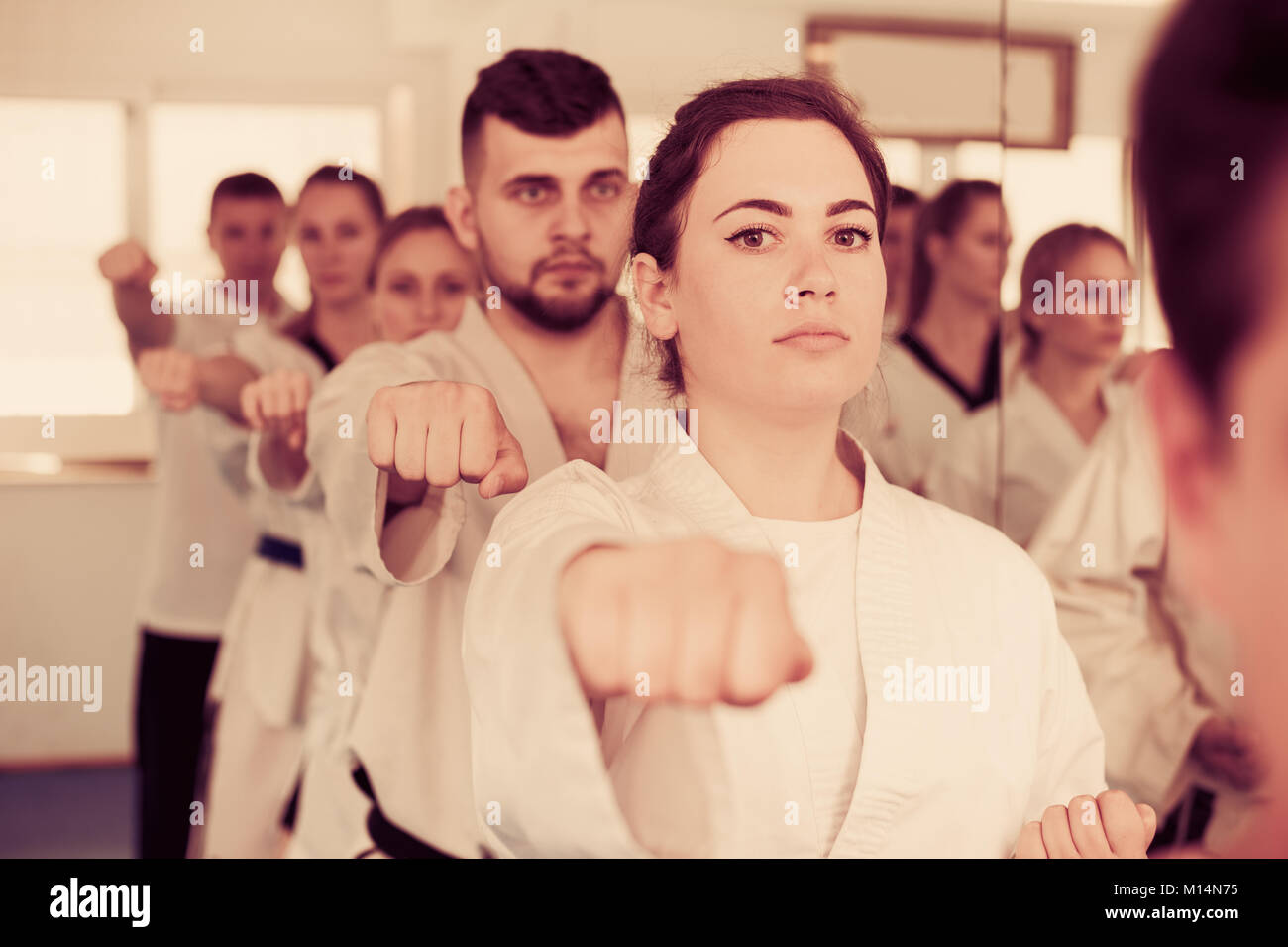 Group of people trying new martial moves in practice during karate ...