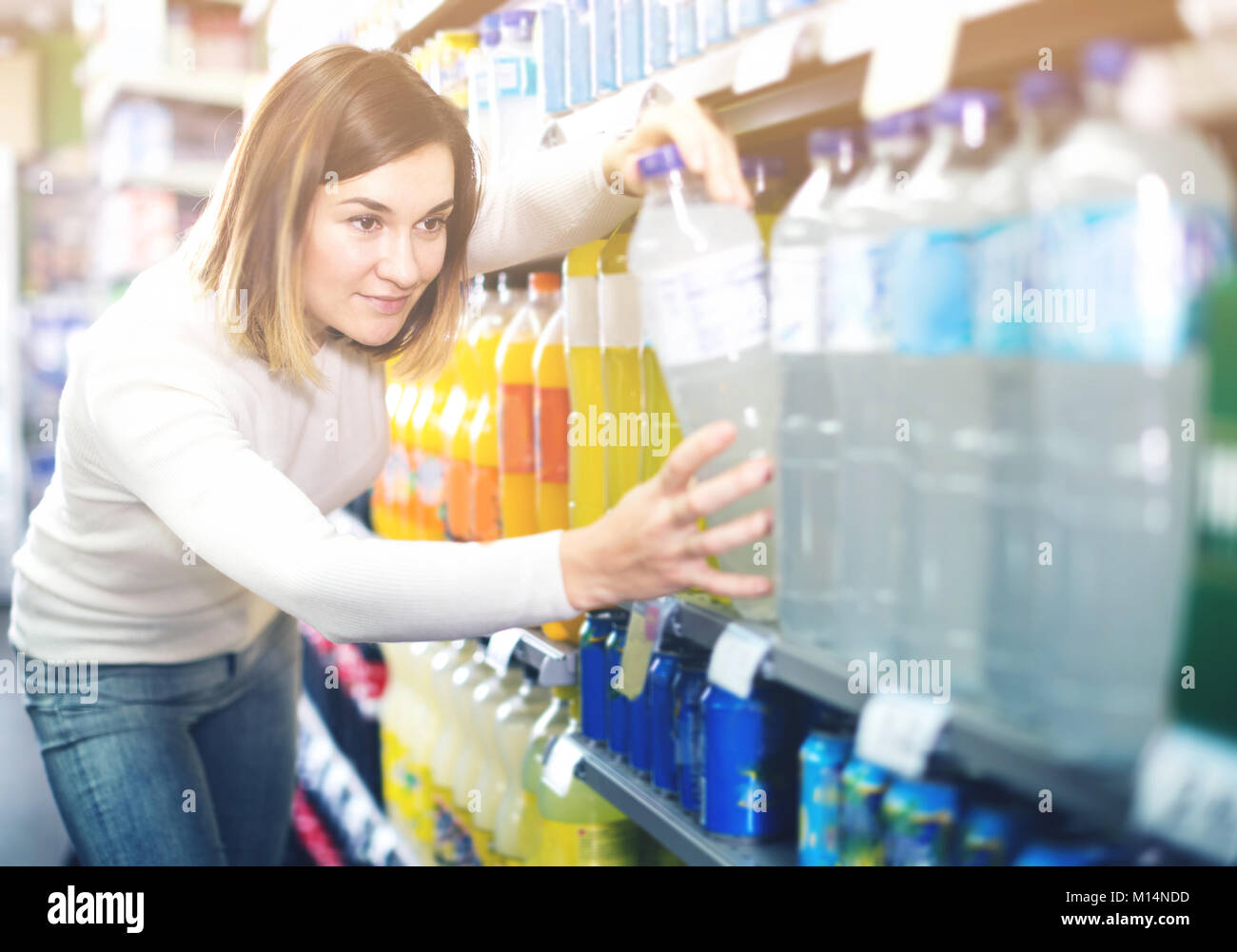 Girl customer looking for the refreshing beverages in the supermarket ...