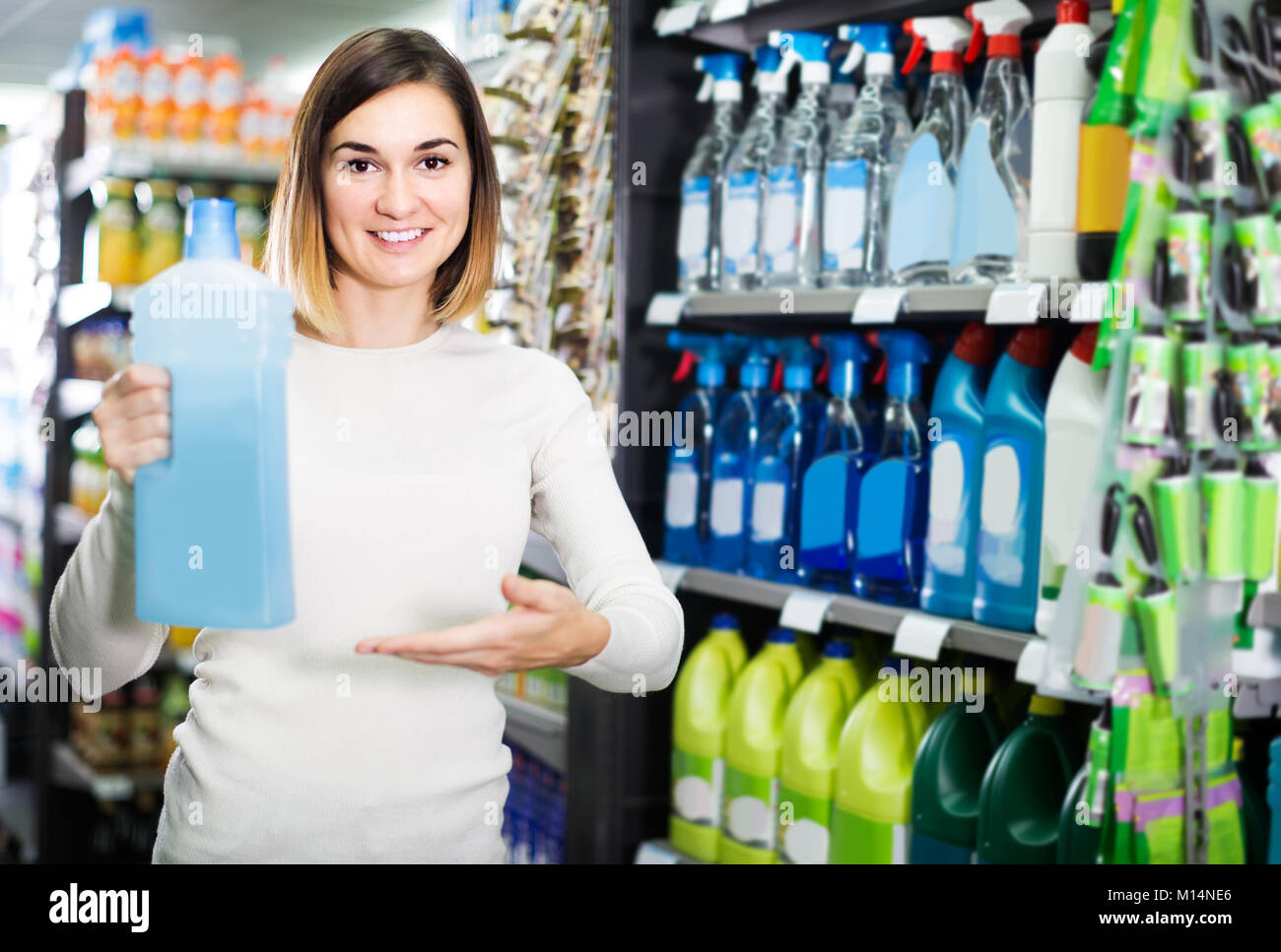 Young american woman choosing best cleaners for home in supermarket ...