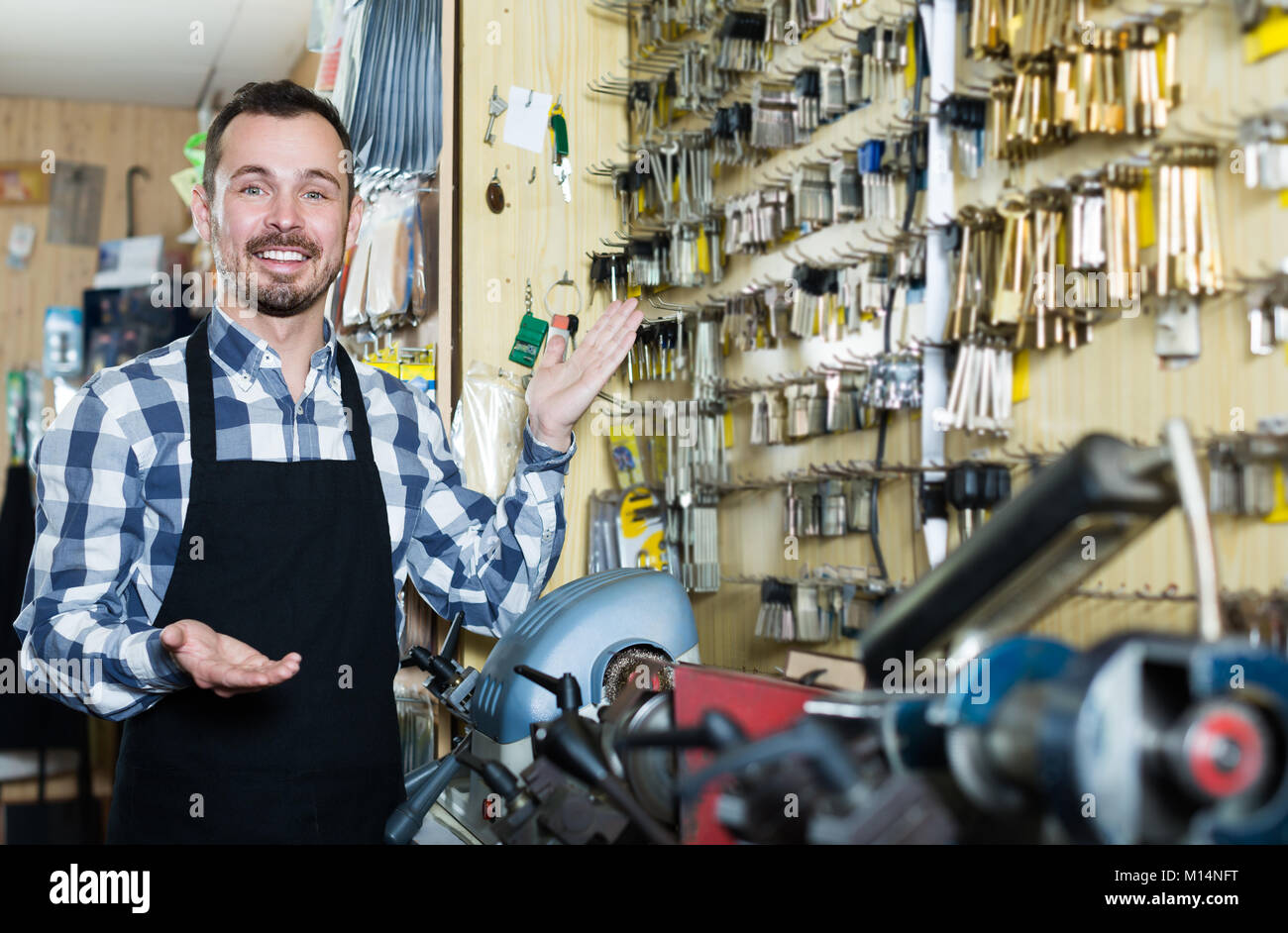 Smiling male worker showing his tools for making keys in workshop Stock ...