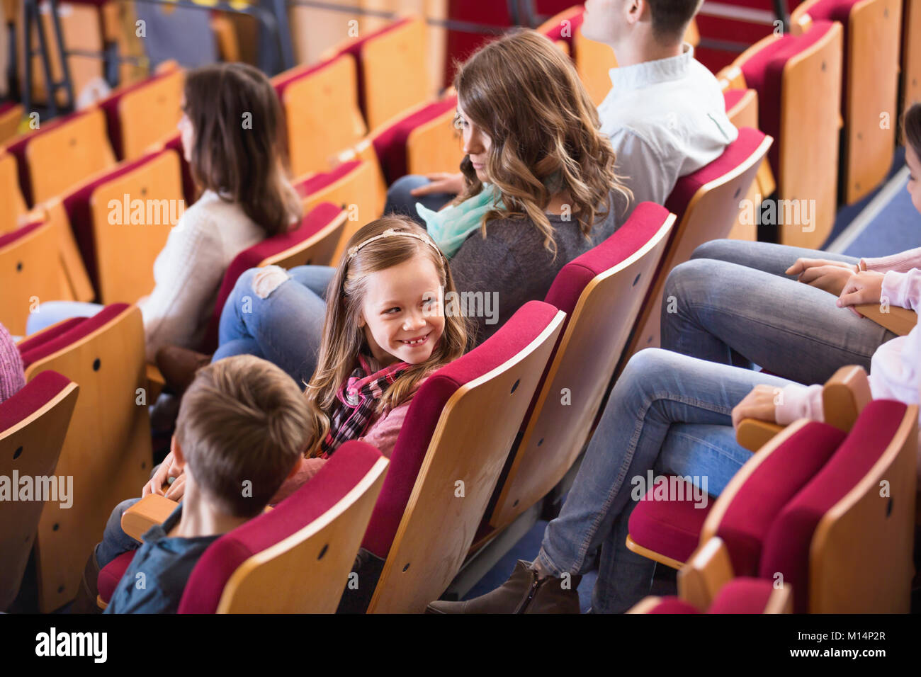 Cheerful female child looking away from screen in cinema house Stock ...