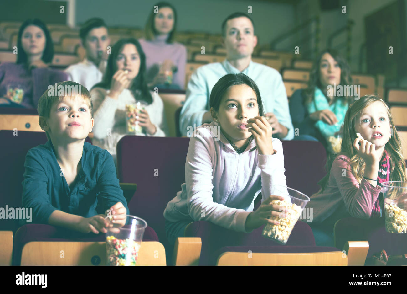 Group of people eating popcorn during film in cinema Stock Photo - Alamy