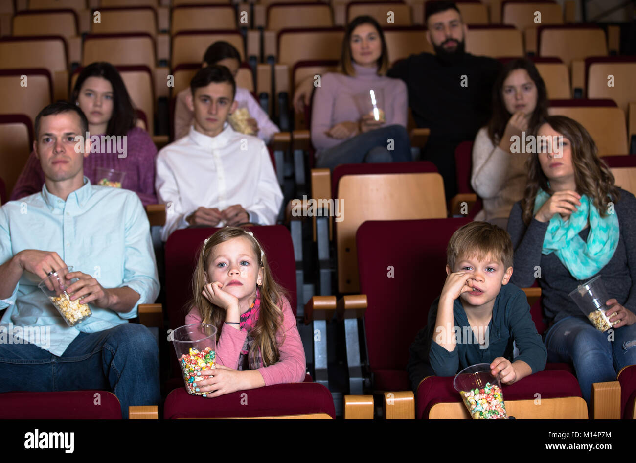 Enthusiastic audience eating popcorn and enjoy watching movie in the ...