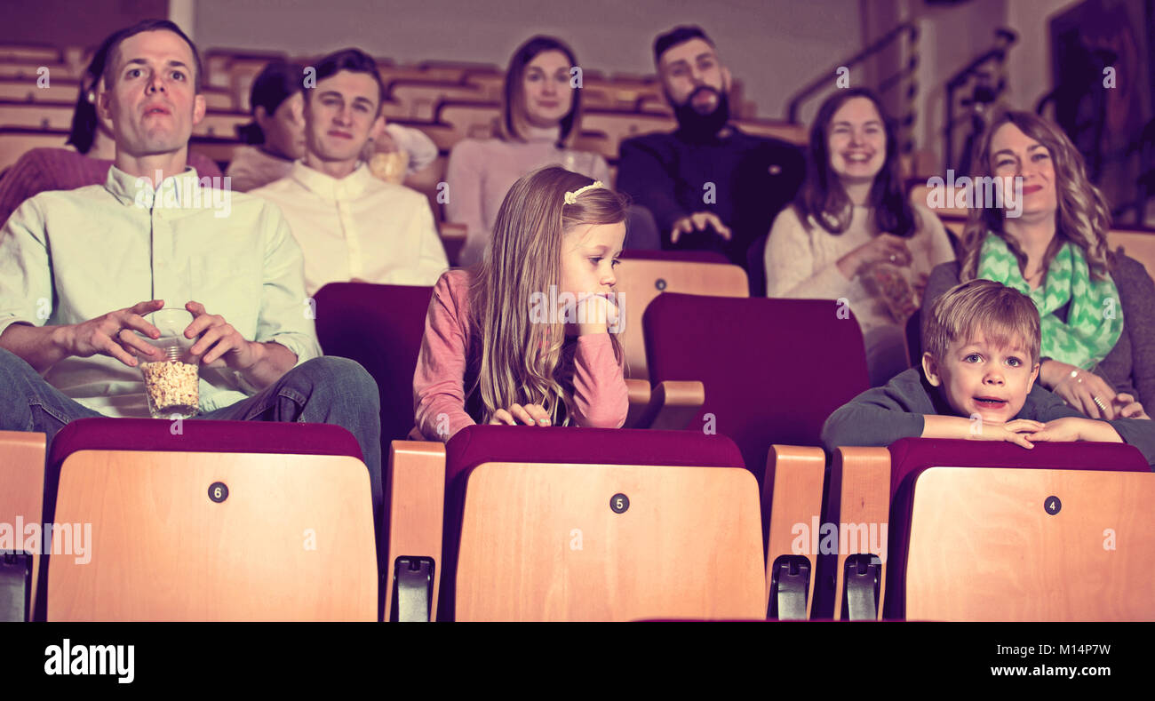 Little child watching boring movie in cinema house Stock Photo - Alamy