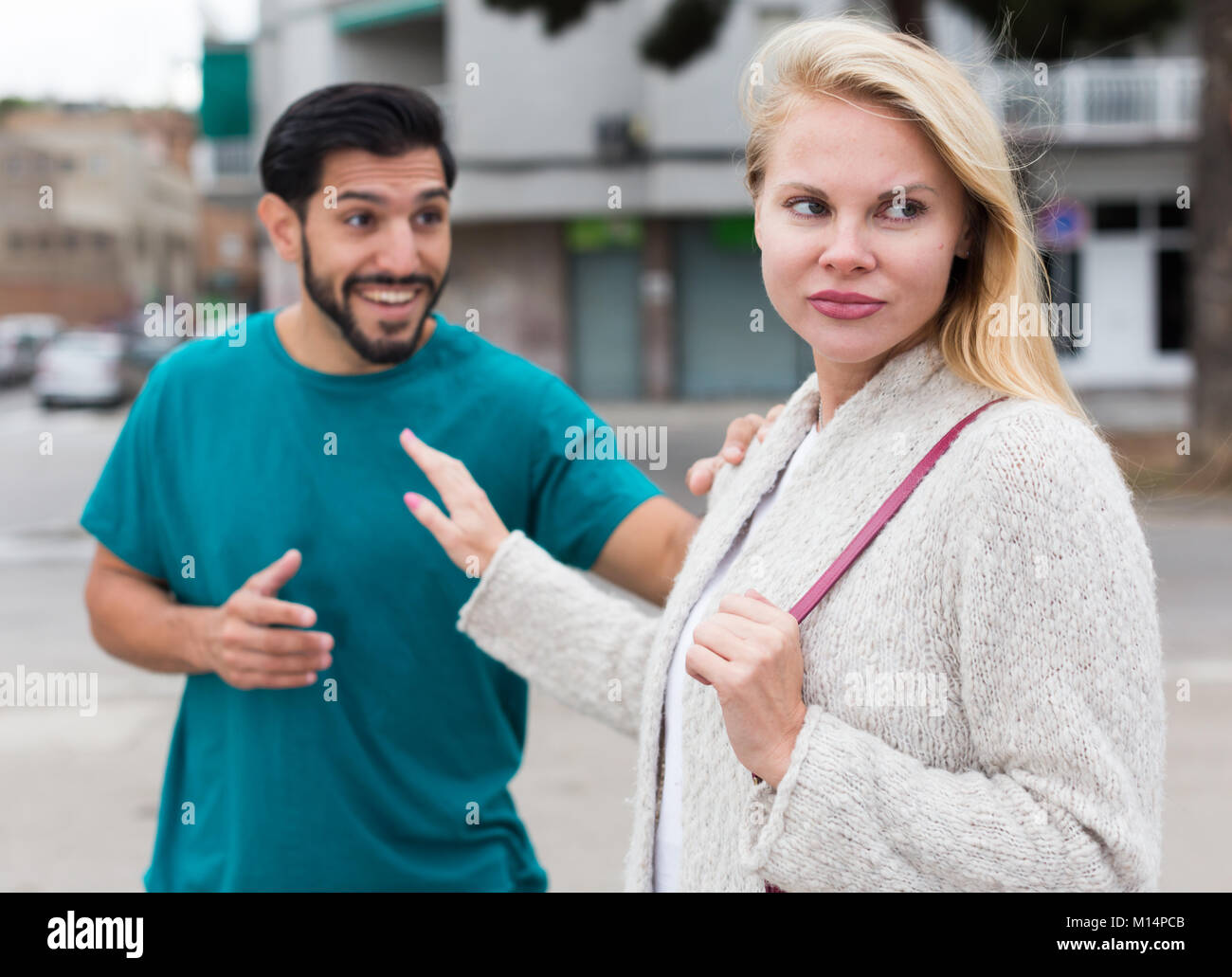 Portrait of female who is angering to adult stranger on the street ...