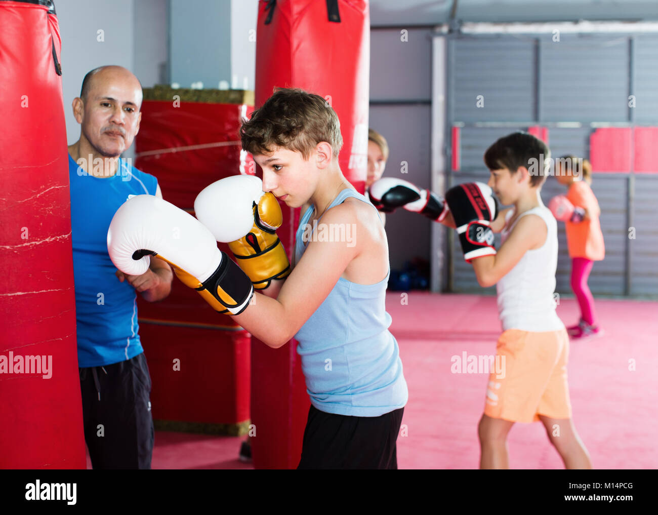 Teenage boy training at boxing at gym with coach Stock Photo - Alamy