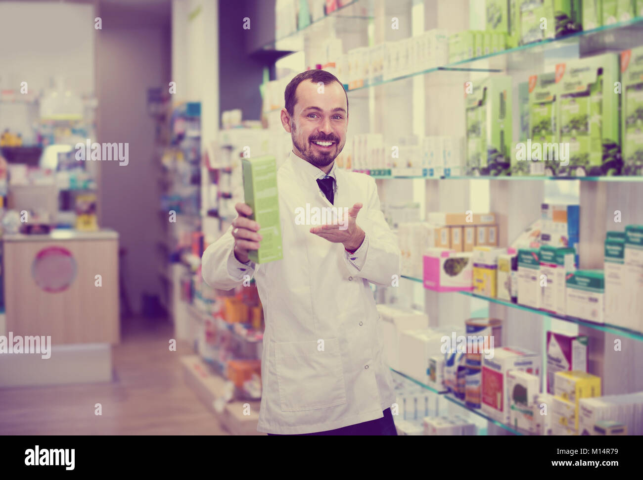 Smiling male pharmacist showing right pills in pharmacy Stock Photo - Alamy