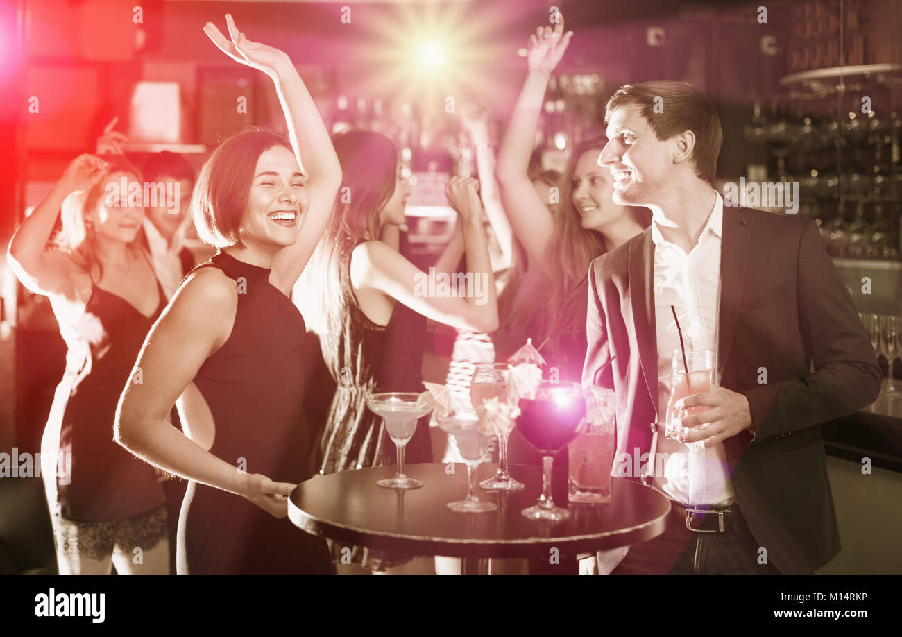 Positive glad colleagues dancing on corporate party with cocktails in ...