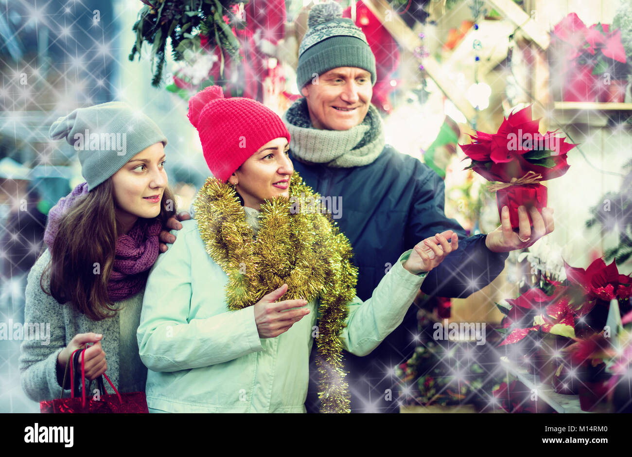 smiling russian family of three with teenage girl choosing floral ...