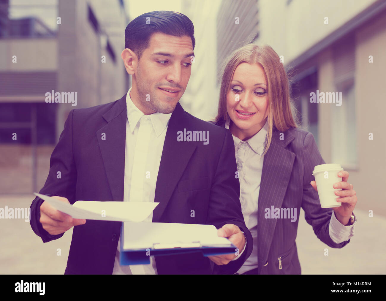 Businesswoman with her employee are drinking coffee and reading ...